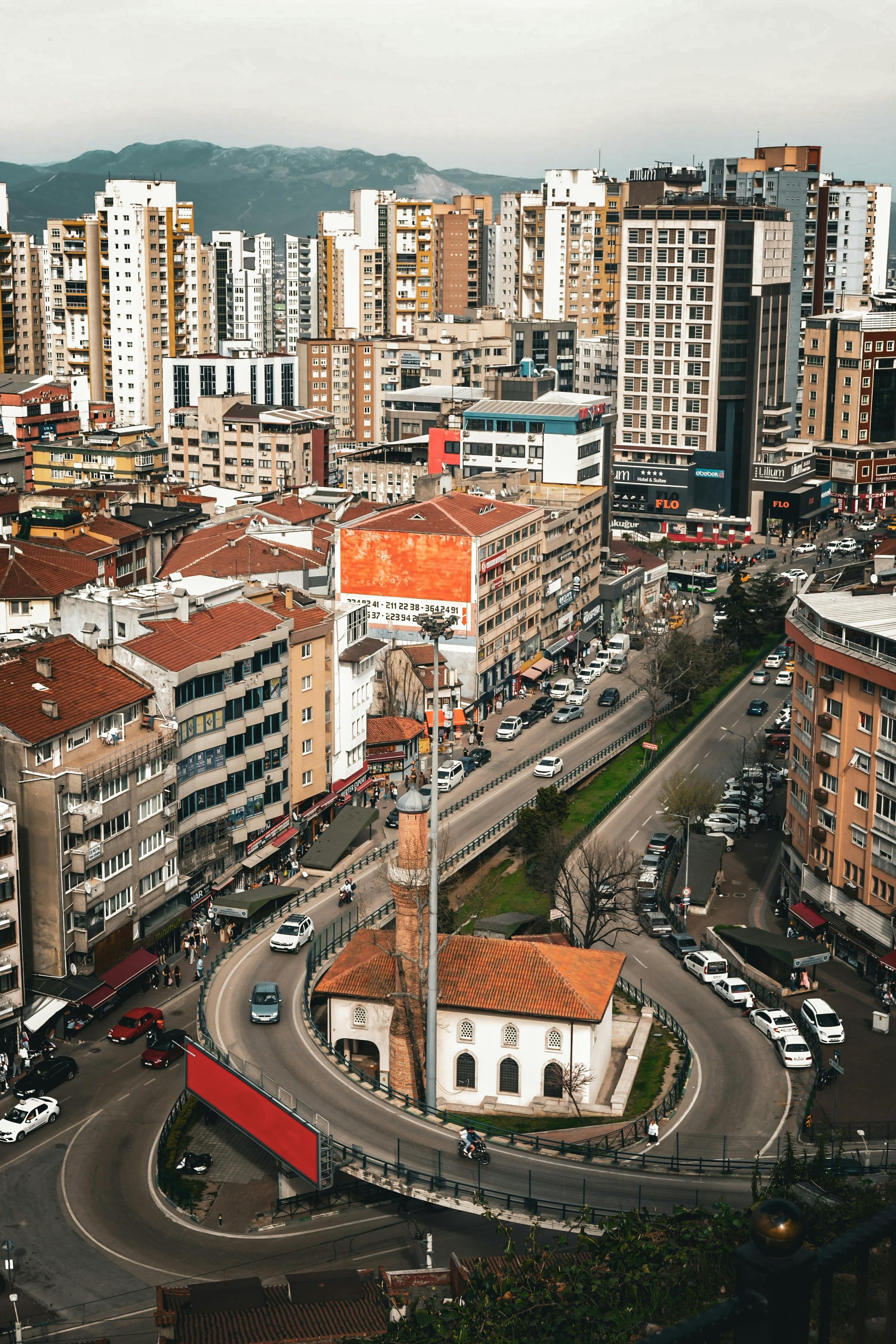 Bustling Cityscape with Circular Mosque in Traffic Circle · Free Stock ...