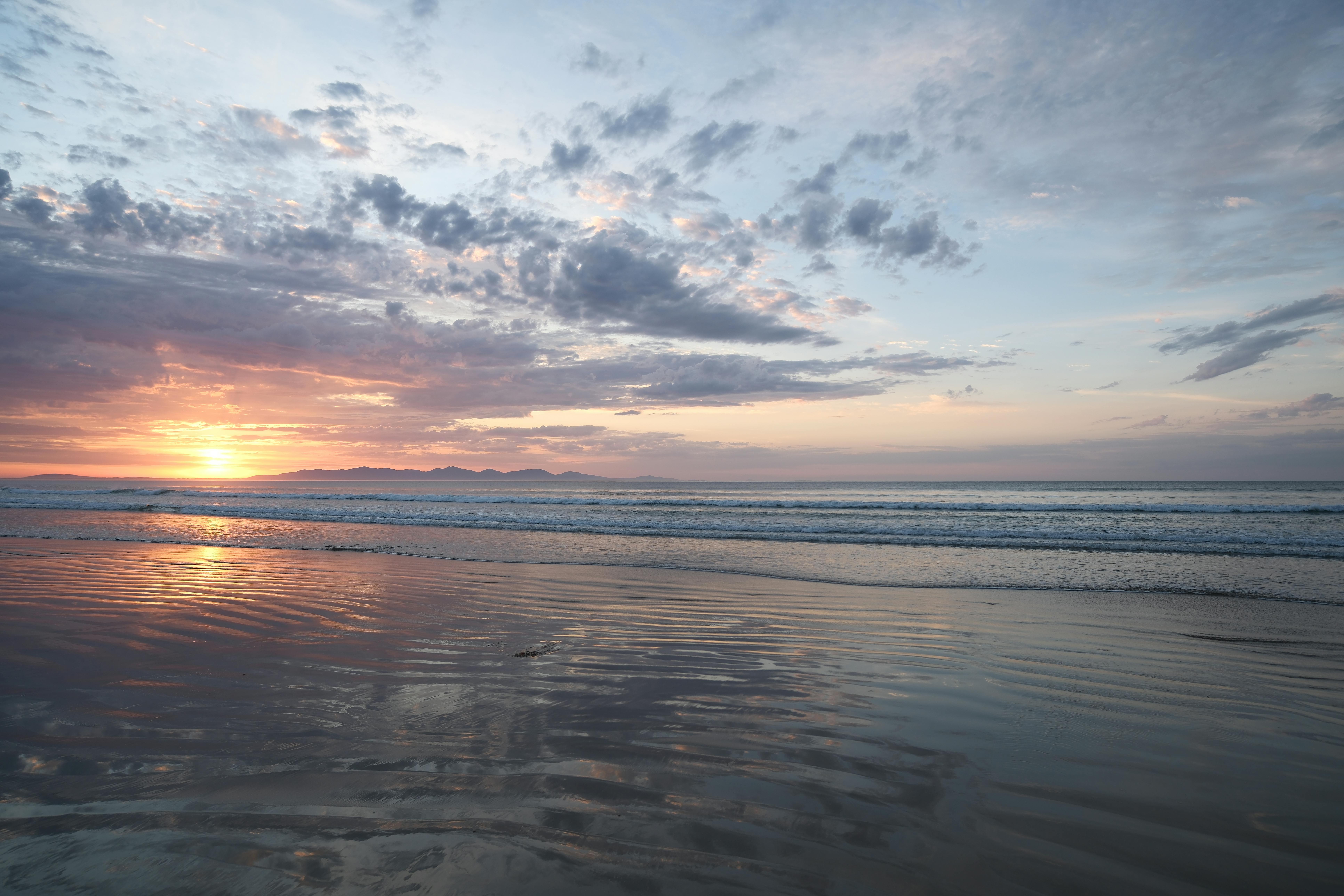 Stunning Beach Sunset with Reflective Ocean Surface · Free Stock Photo