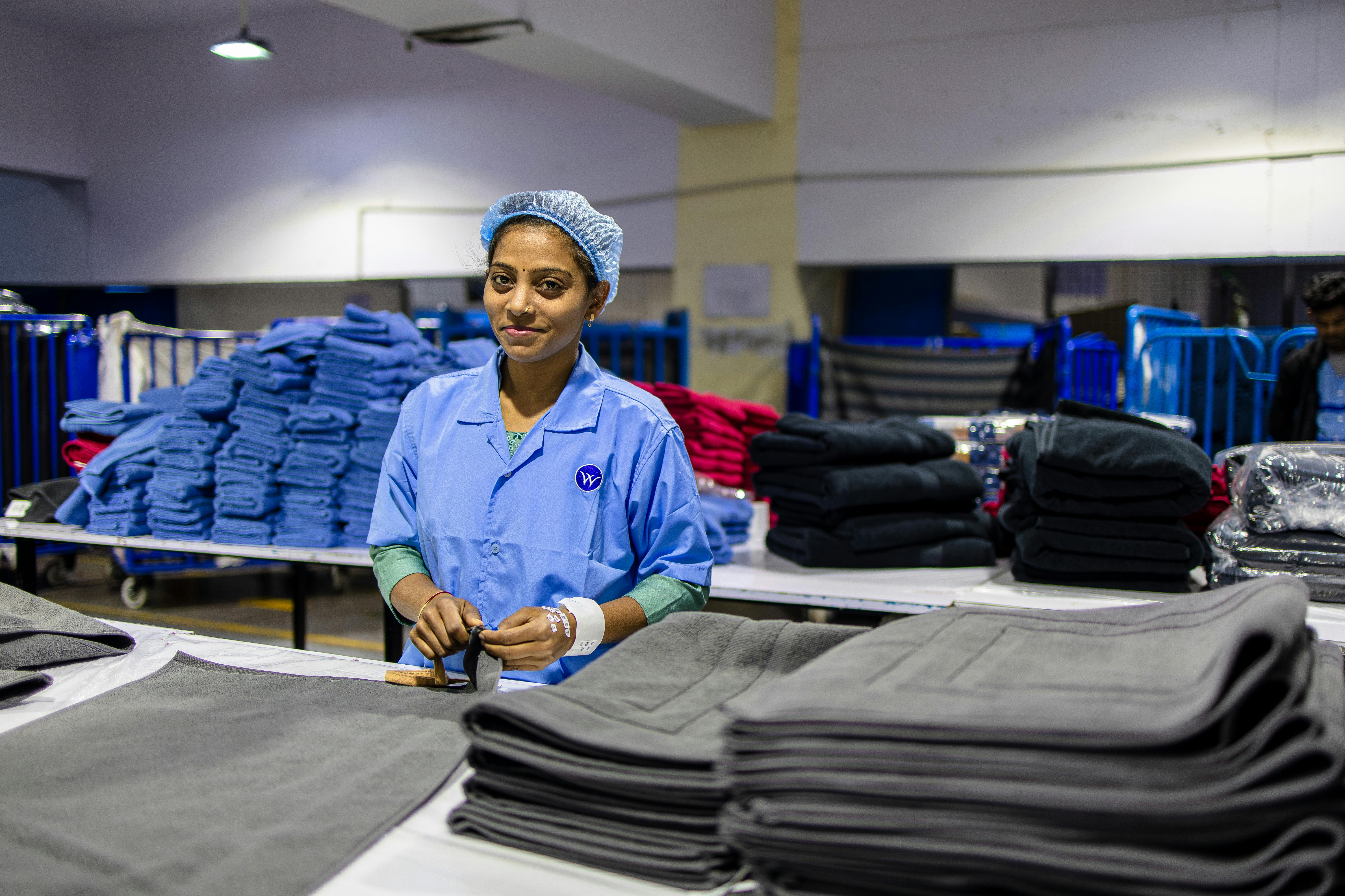 Textile Worker Organizing Fabric in Factory · Free Stock Photo