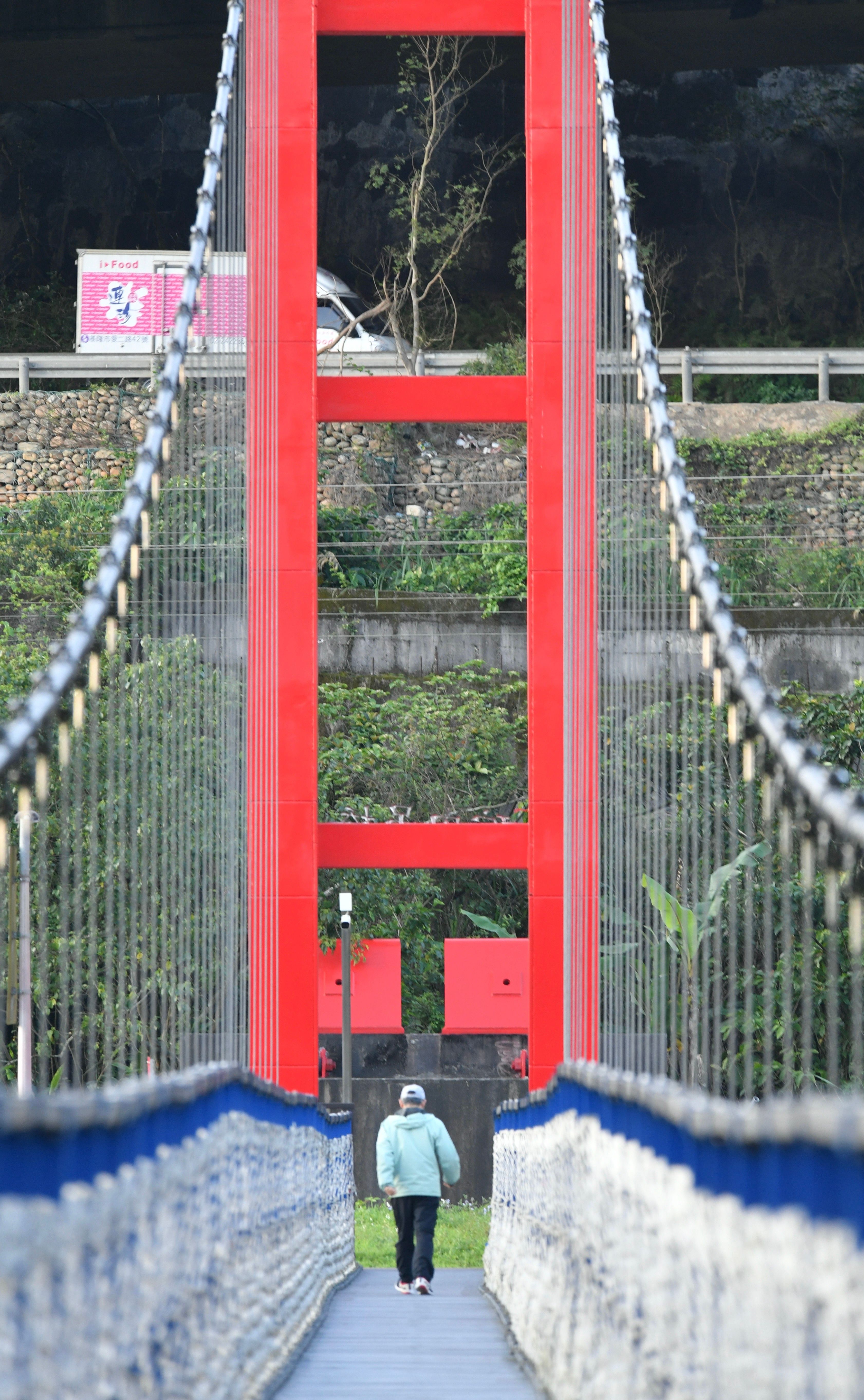 Vibrant Red Suspension Bridge in Scenic Forest Setting · Free Stock Photo