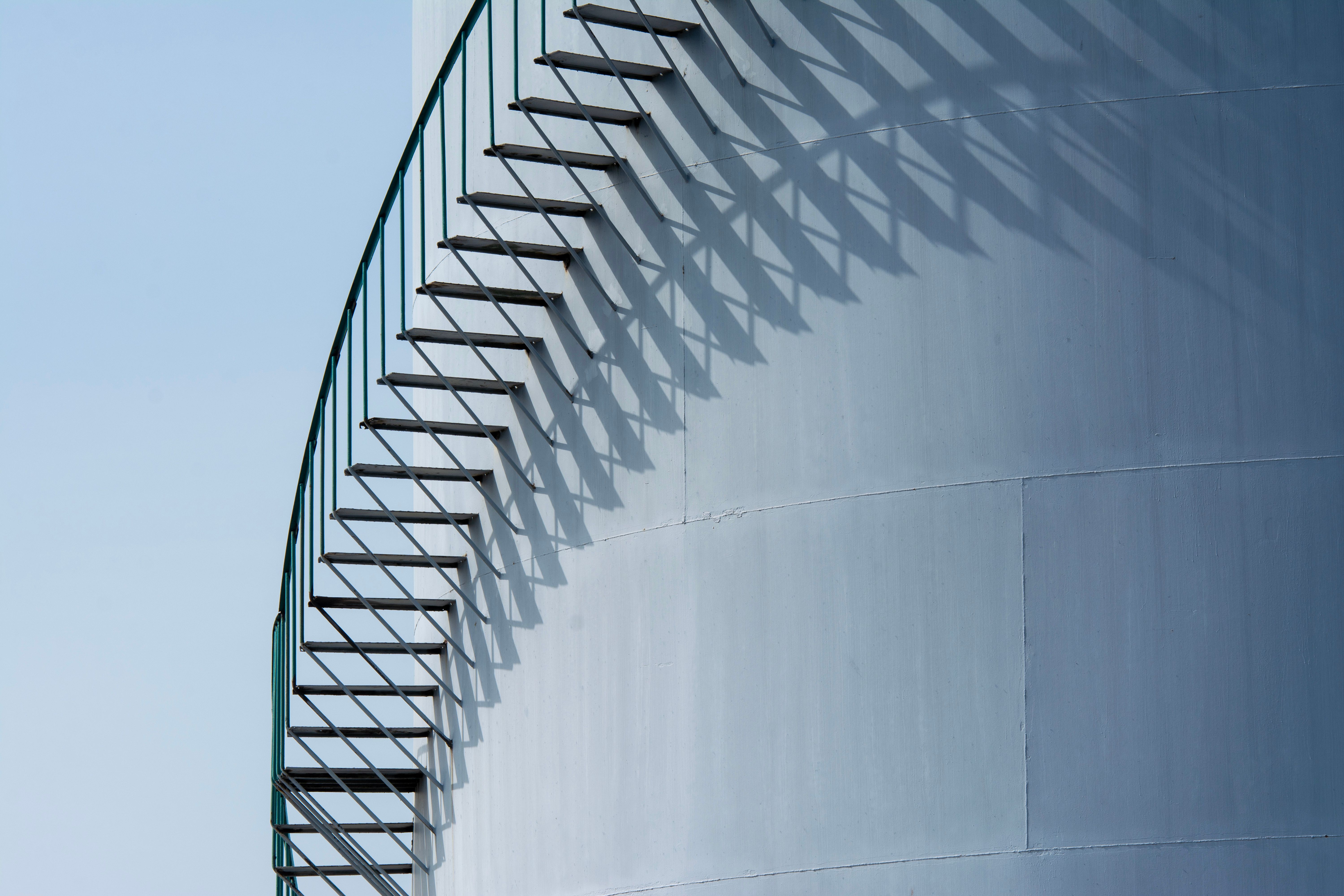 Curved Metal Staircase Casting Shadows on Wall · Free Stock Photo