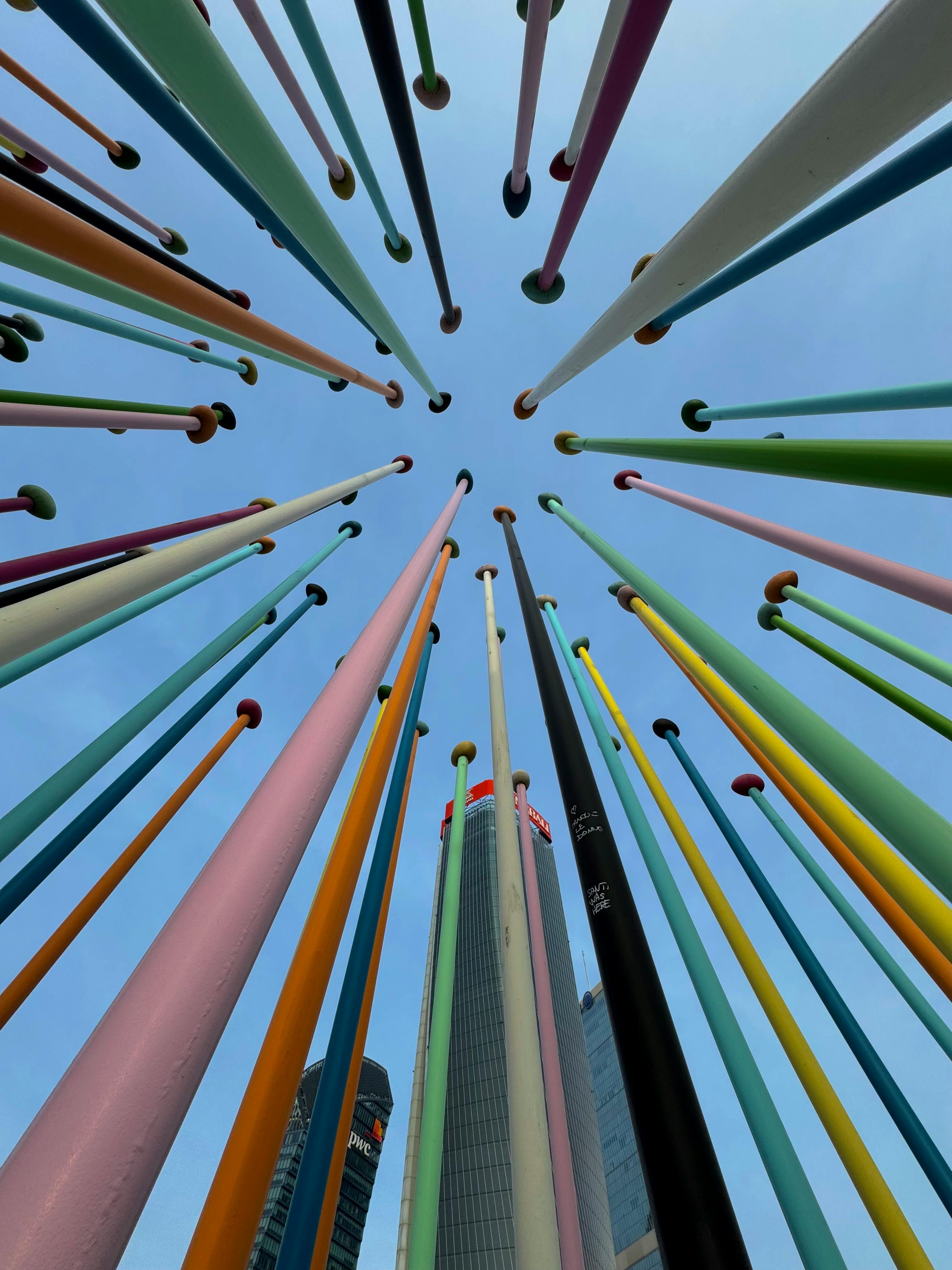 Colorful Poles Against City Skyscrapers · Free Stock Photo