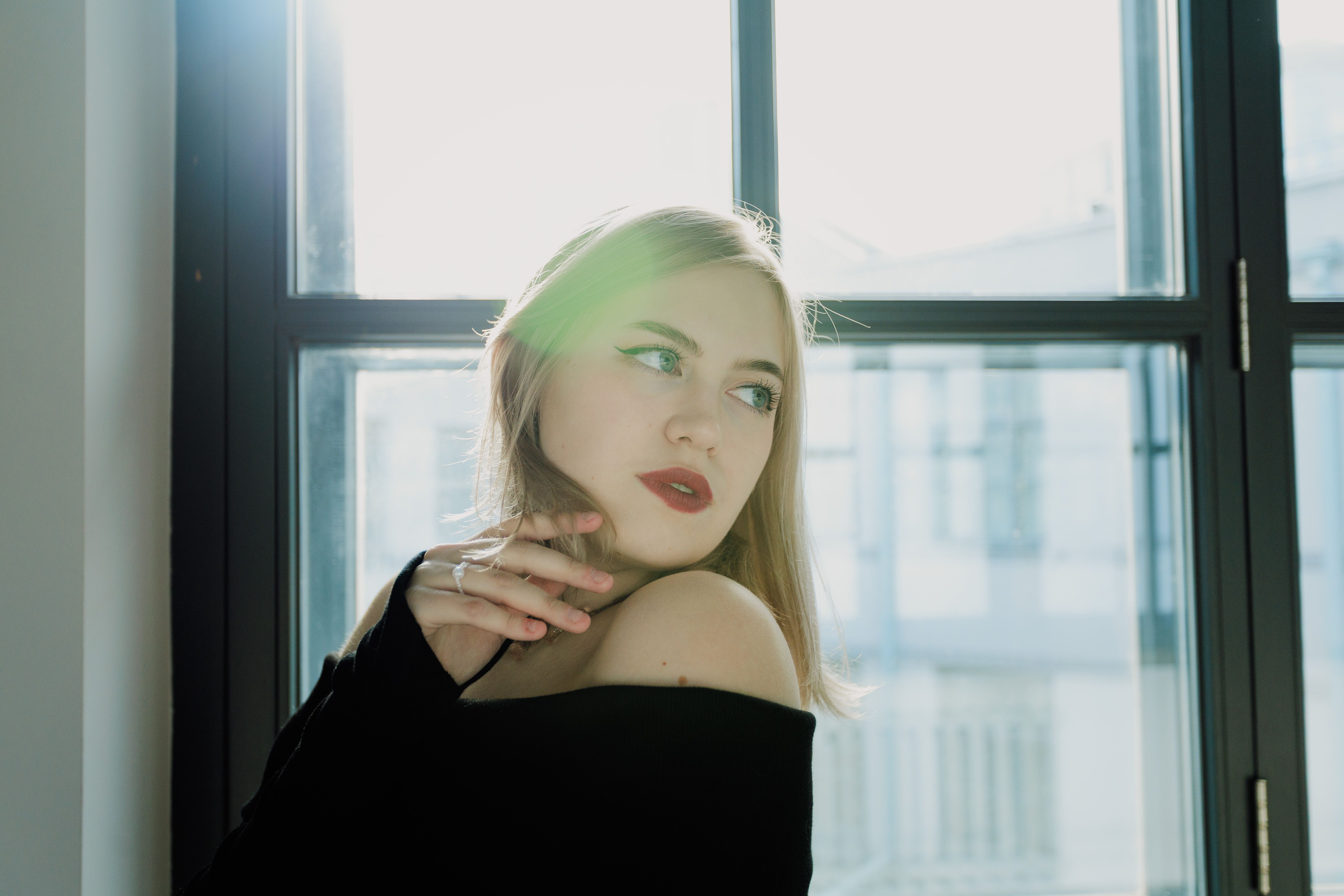 Elegant Woman Posing by Sunlit Window · Free Stock Photo