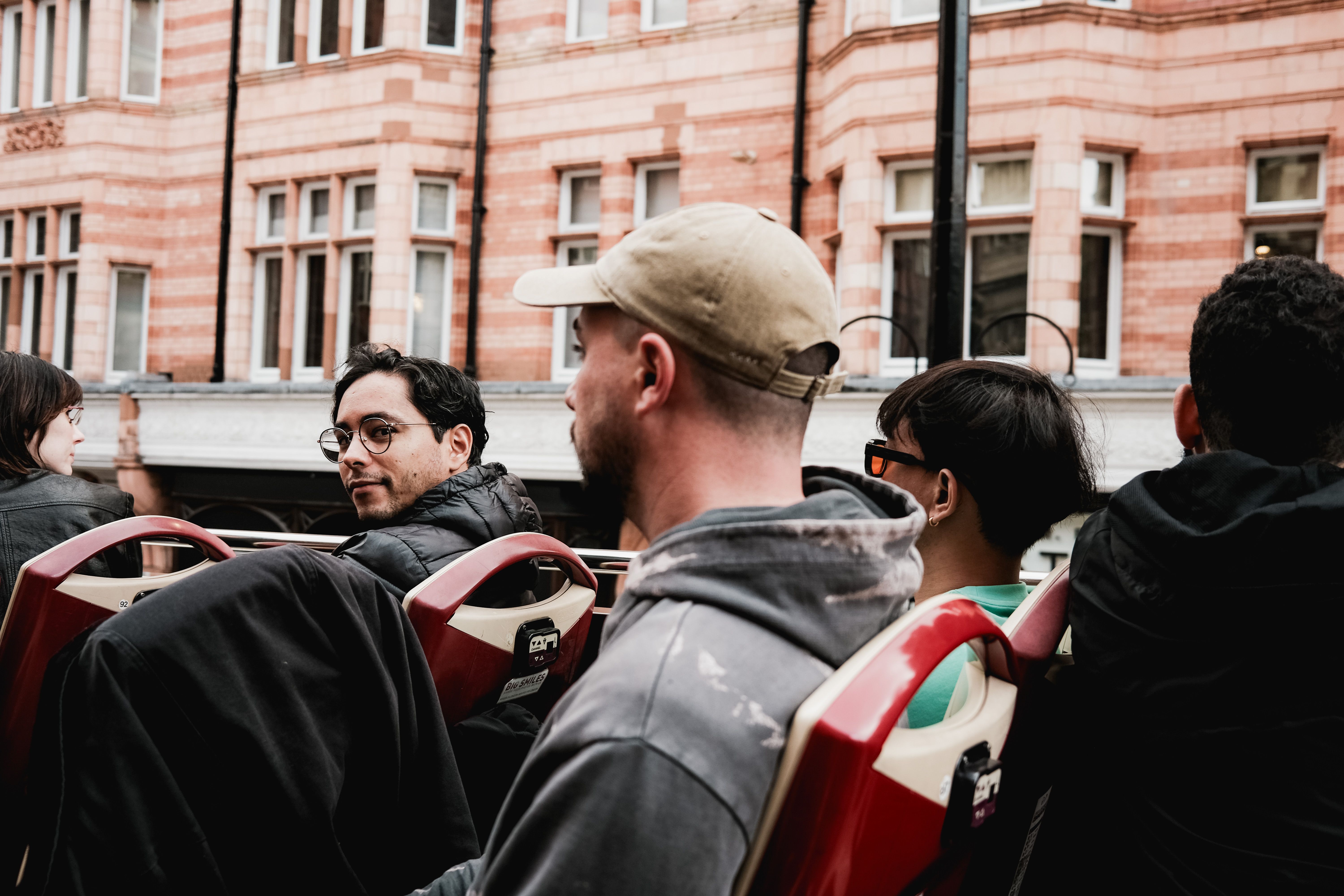 Tourists Enjoying Bus Ride Through City Streets · Free Stock Photo