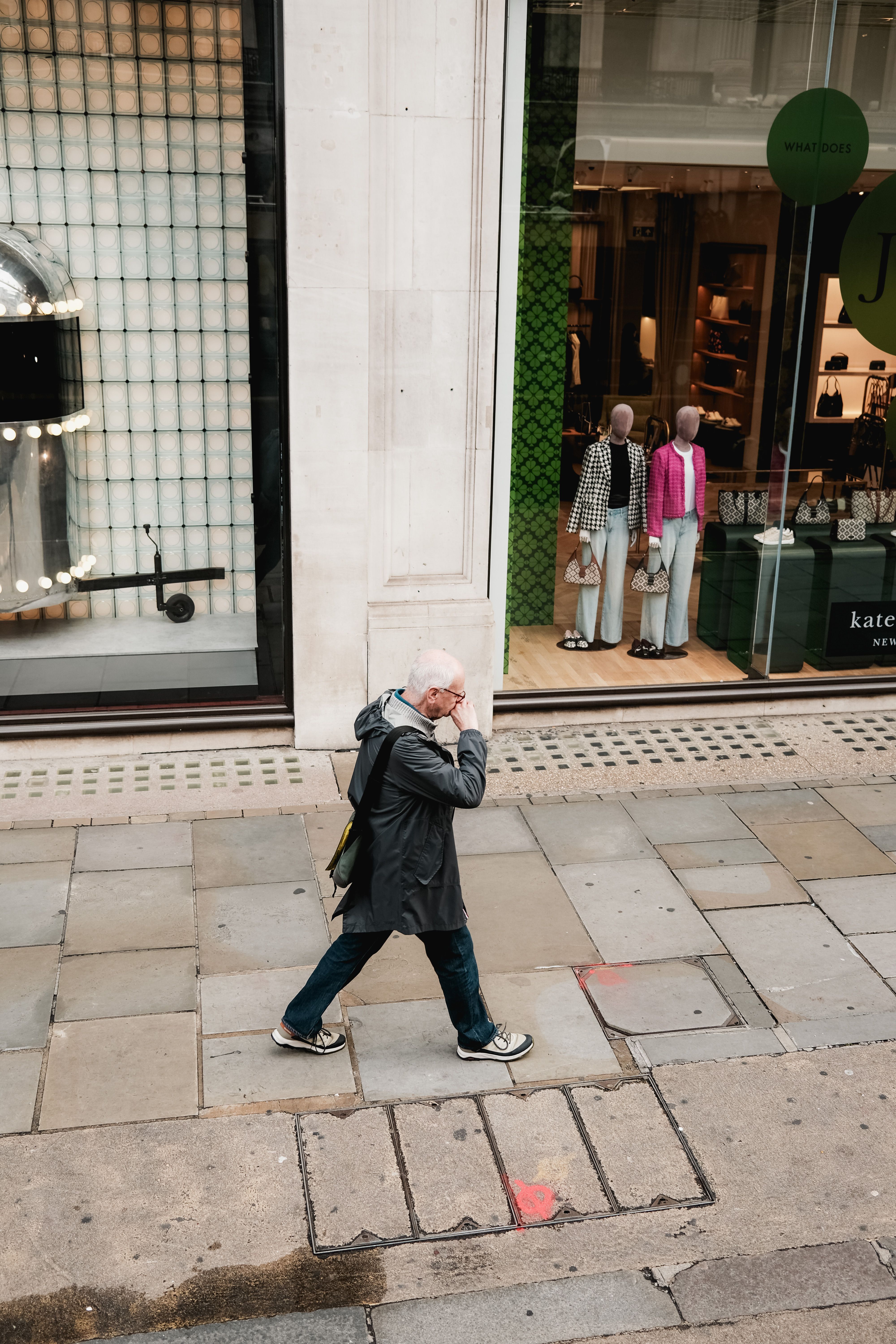 Man Walking Past Fashion Boutique Window Display · Free Stock Photo