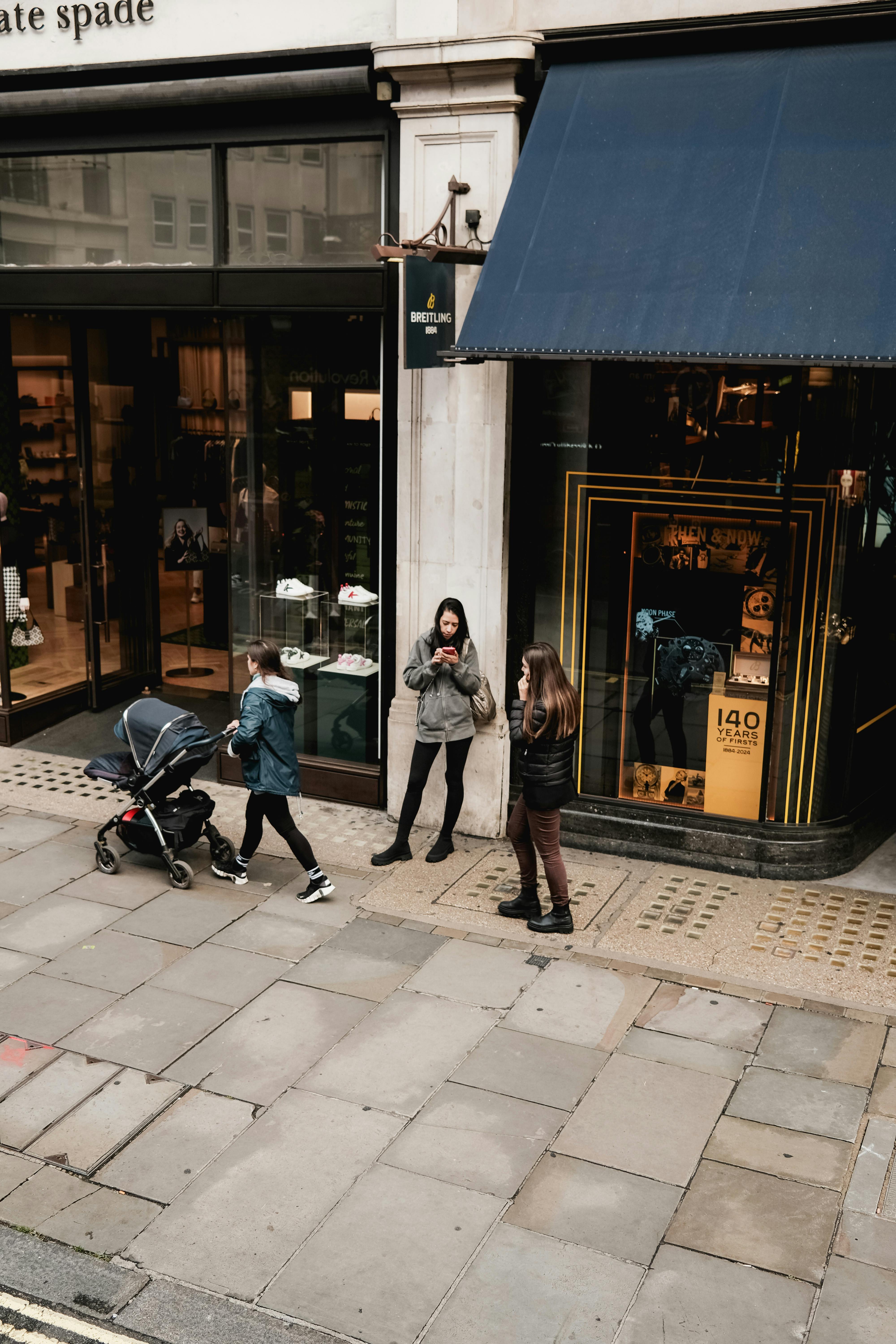 Urban street scene with pedestrians and shops · Free Stock Photo