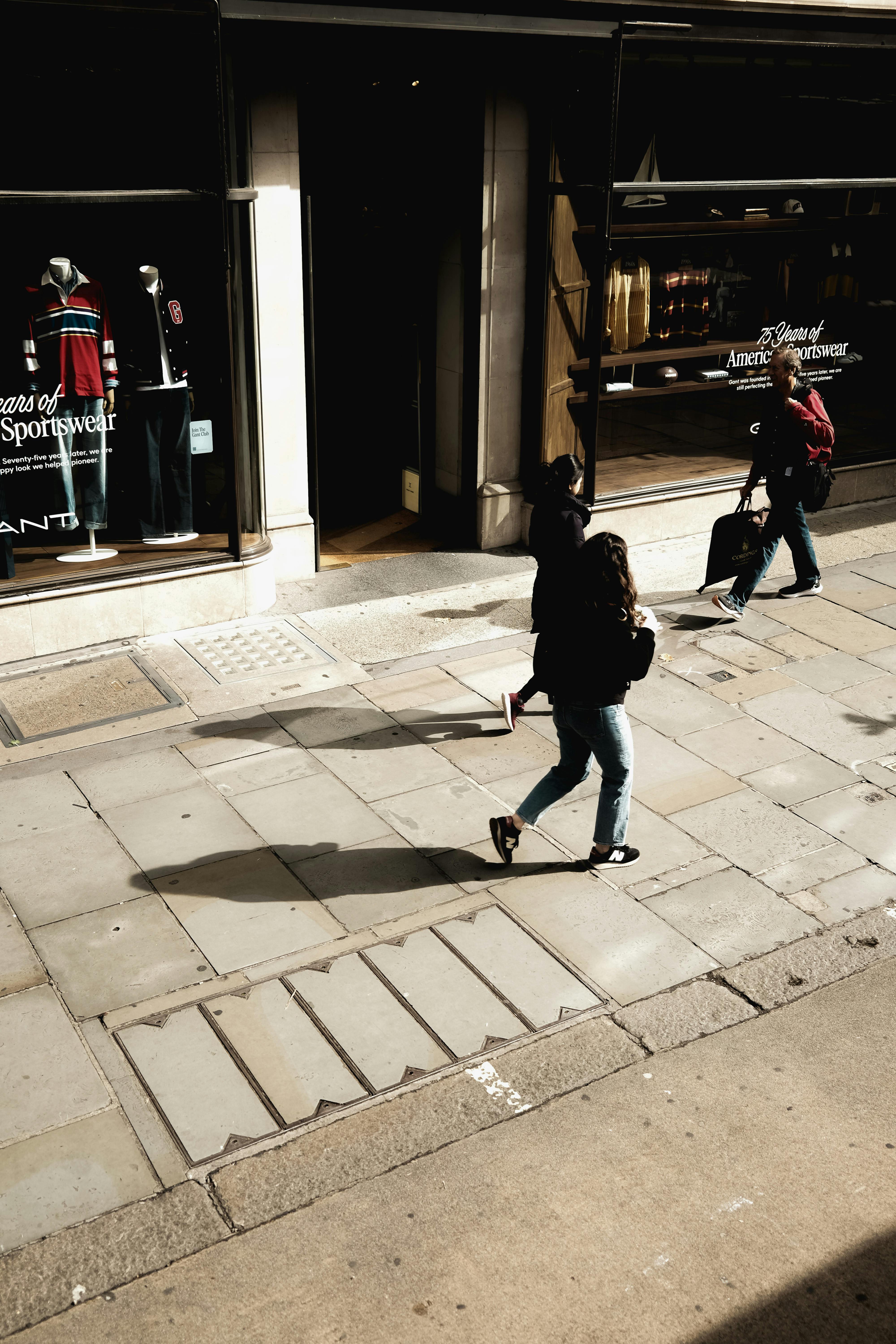 Street View with Pedestrians and Clothing Storefront · Free Stock Photo