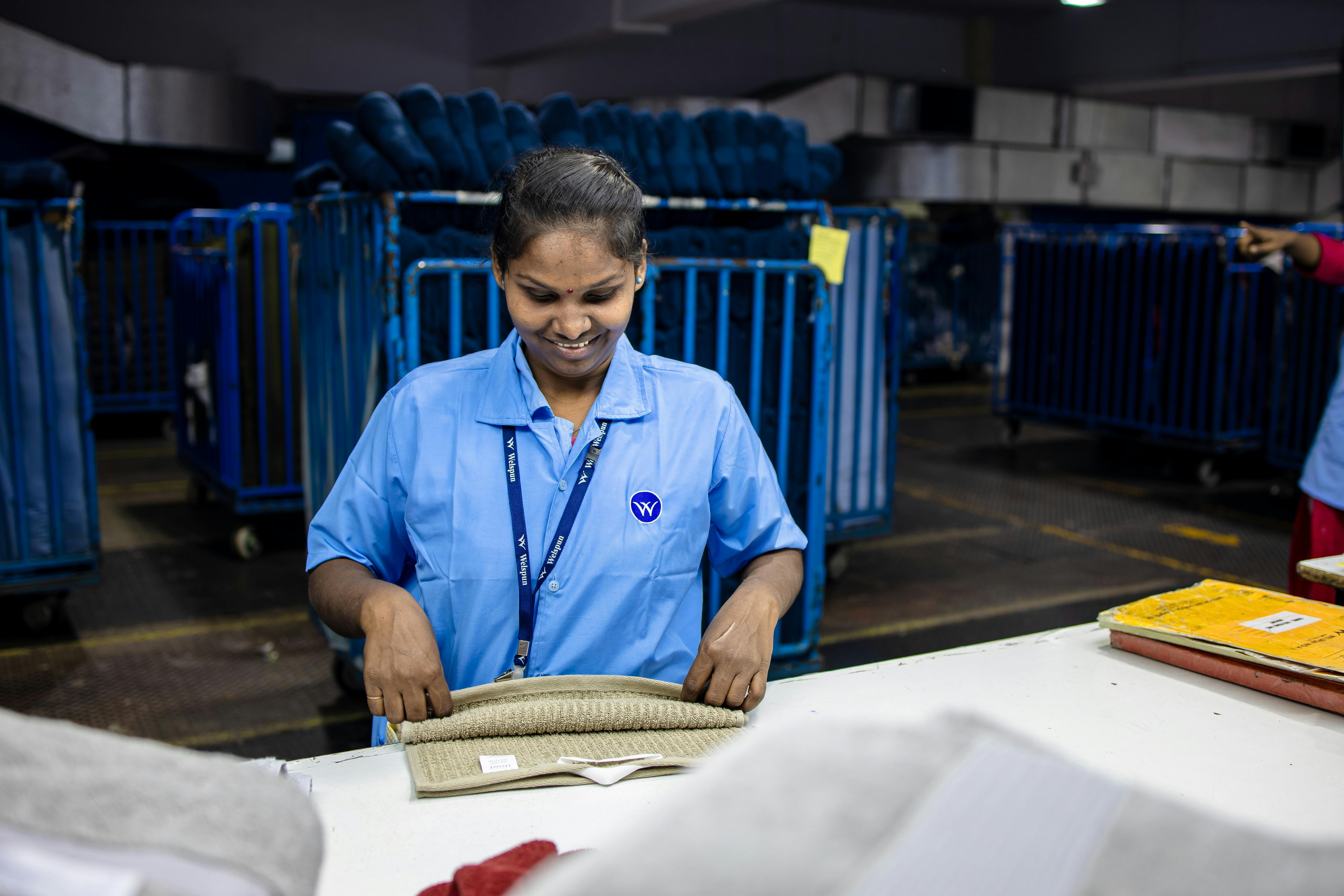 Smiling Textile Worker Sorting Fabrics in Factory · Free Stock Photo