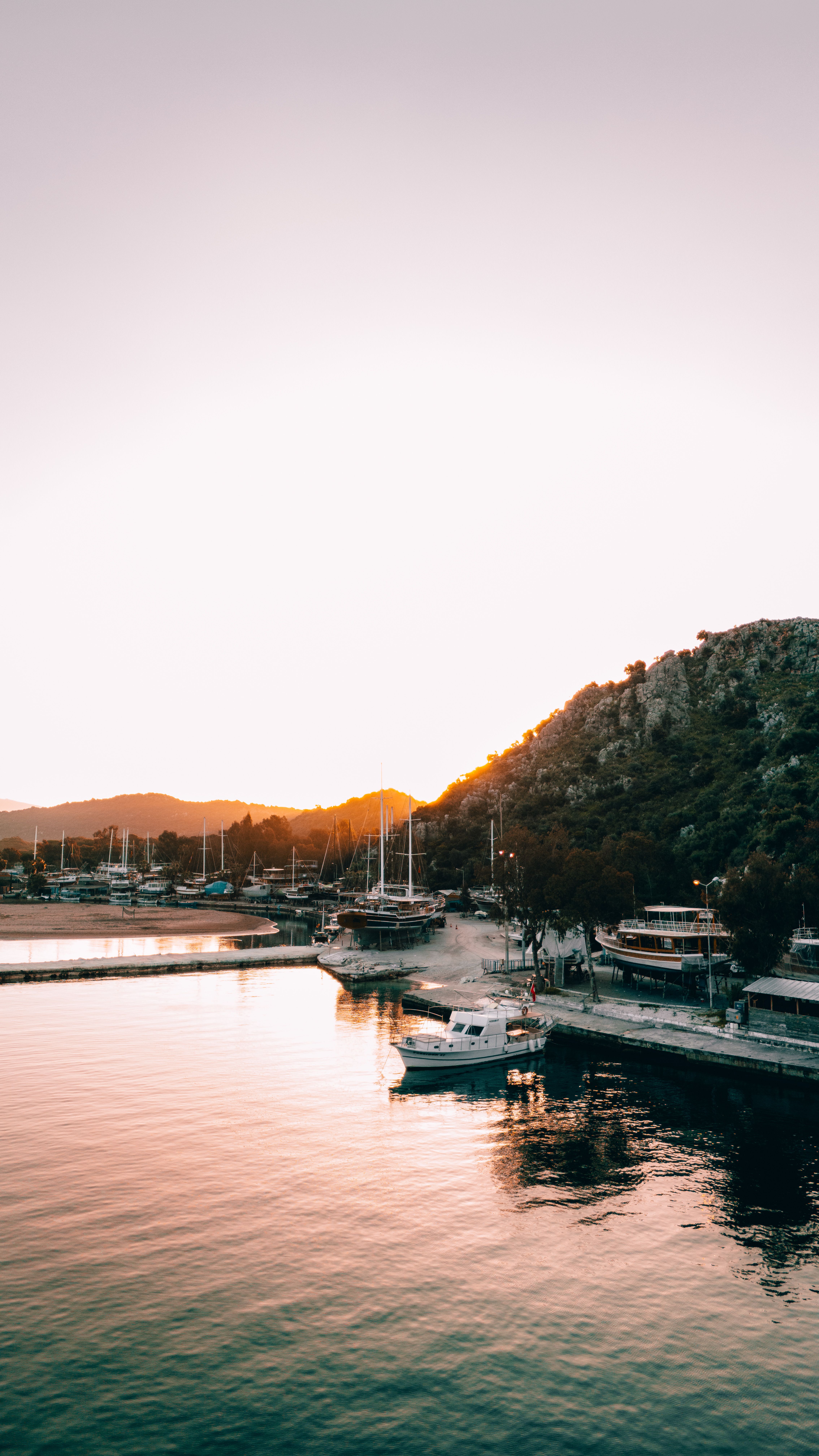 Serene Sunrise Over Coastal Harbor with Boats · Free Stock Photo