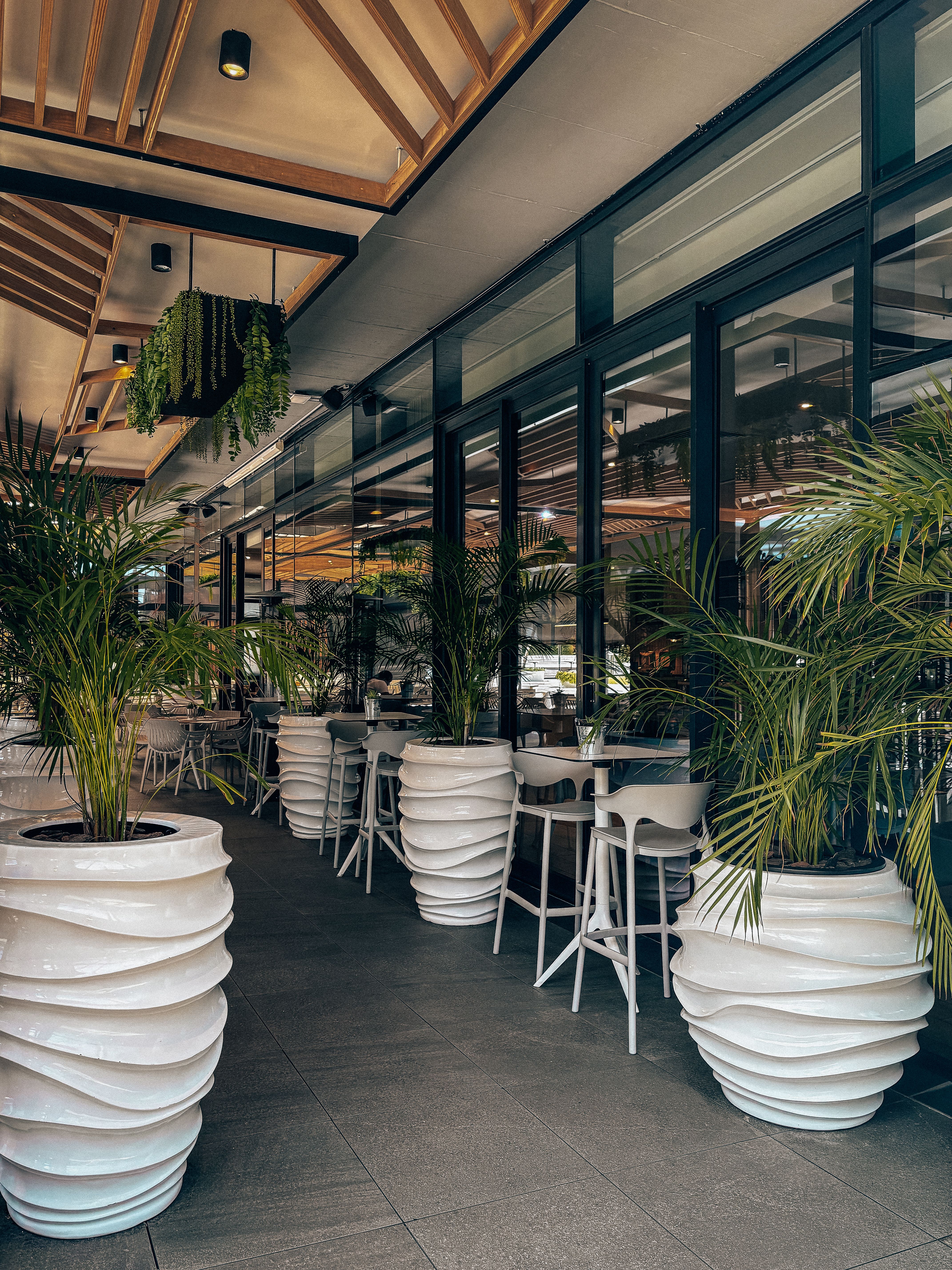 Modern Outdoor Cafe with Stylish Decor and Greenery · Free Stock Photo