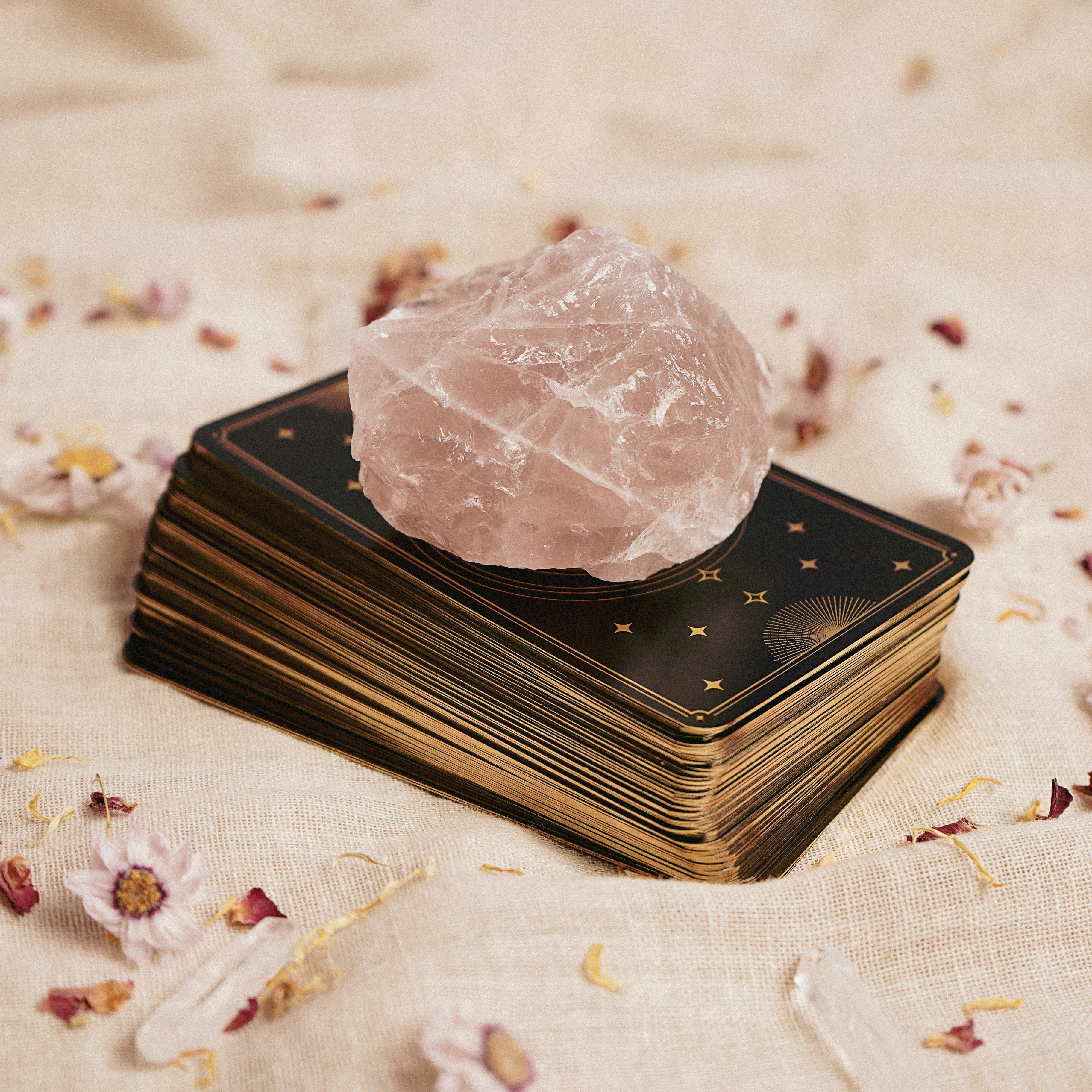 Rose Quartz on Tarot Cards Among Petals · Free Stock Photo