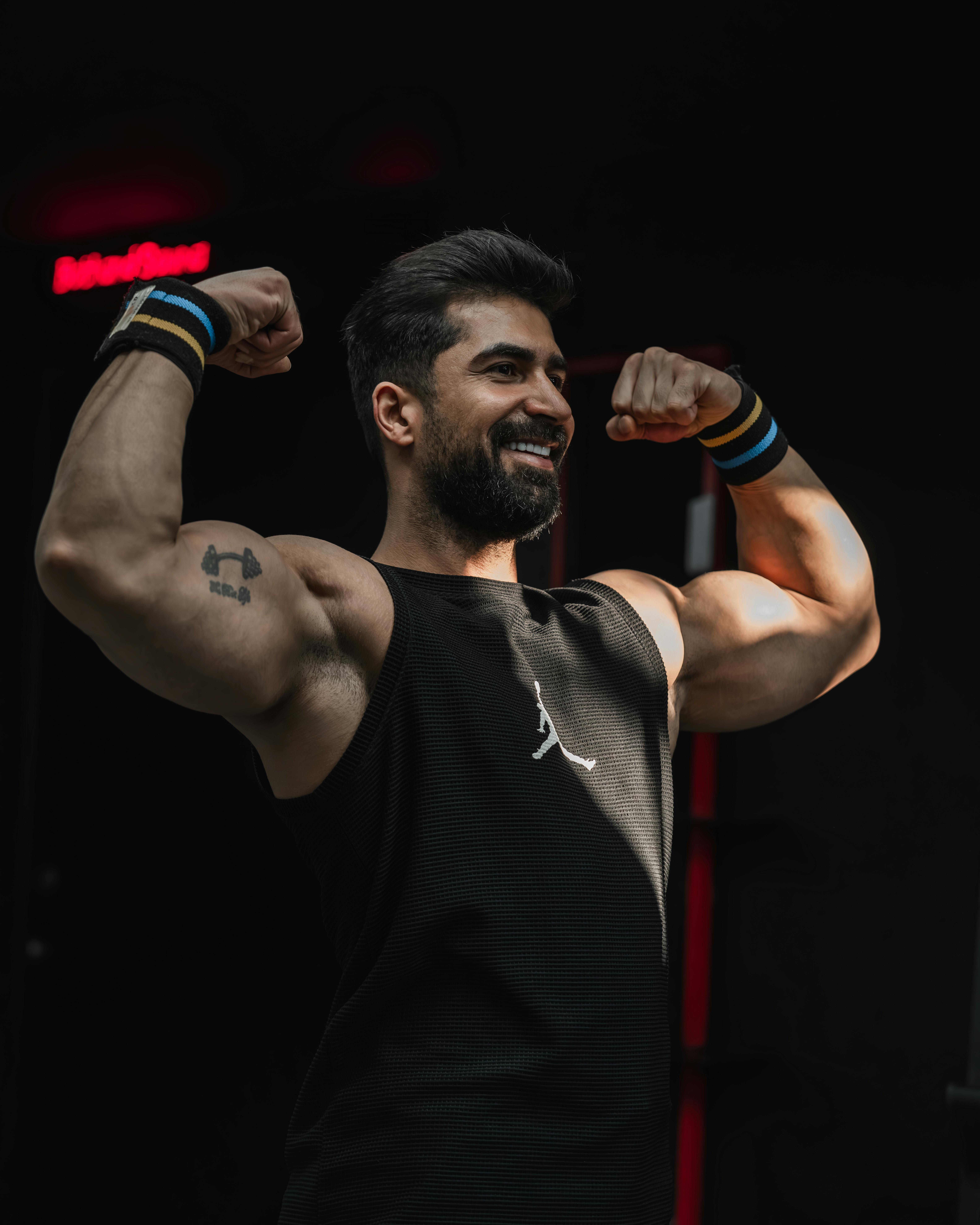 A Muscular Man Flexing His Muscles at the Gym · Free Stock Photo