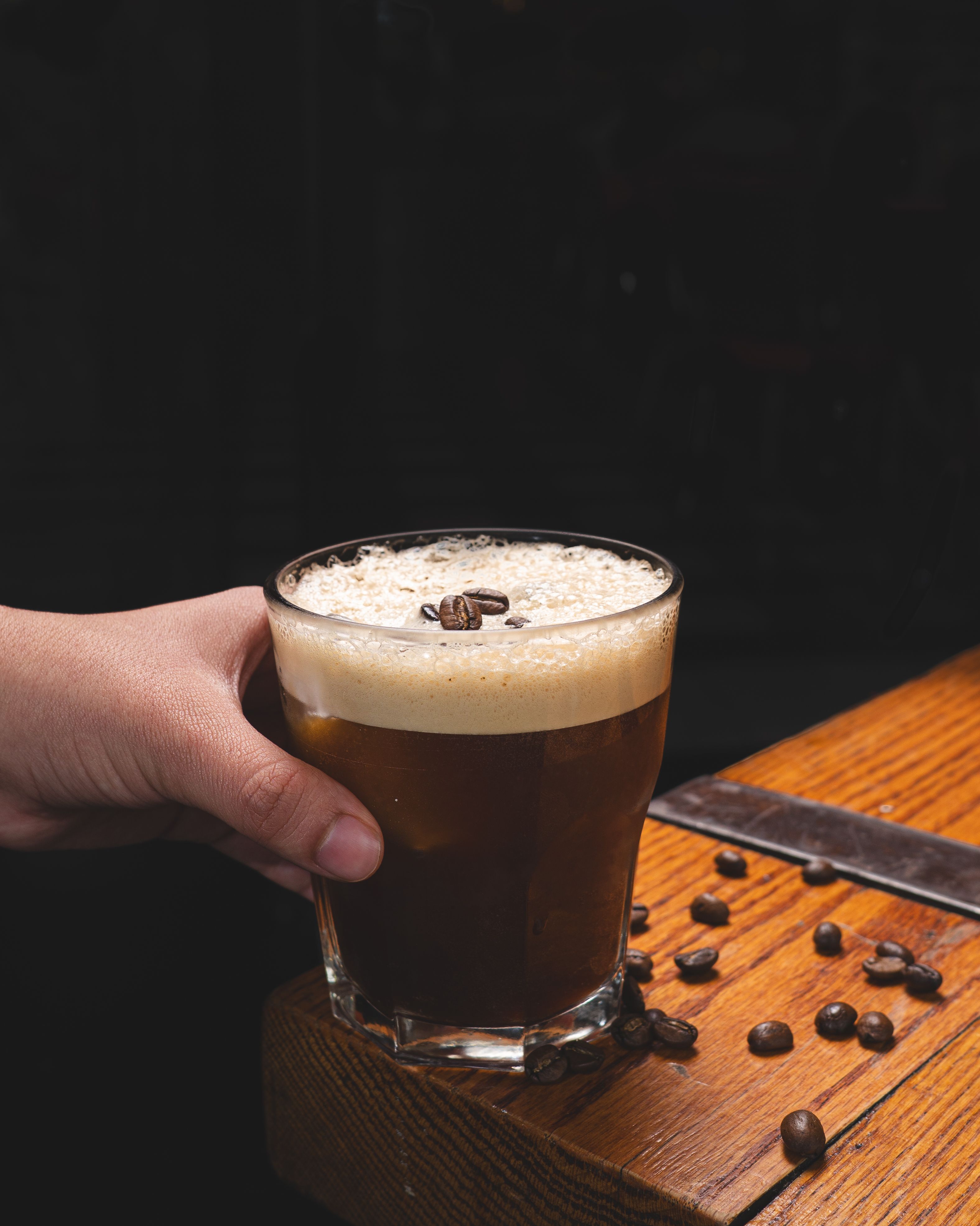 Hand Holding a Freshly Brewed Iced Coffee · Free Stock Photo