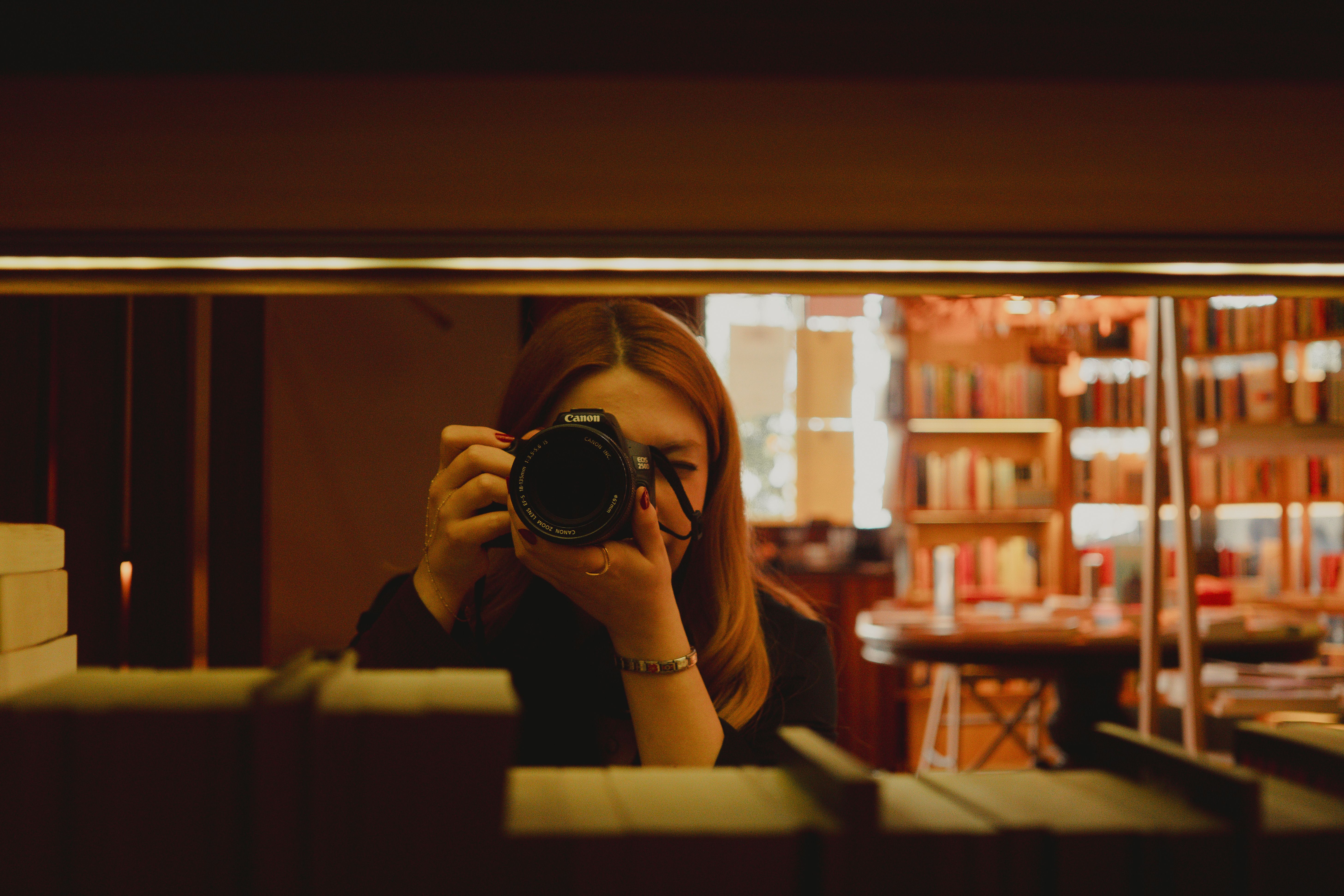 Woman Photographer in Cozy Library Setting · Free Stock Photo