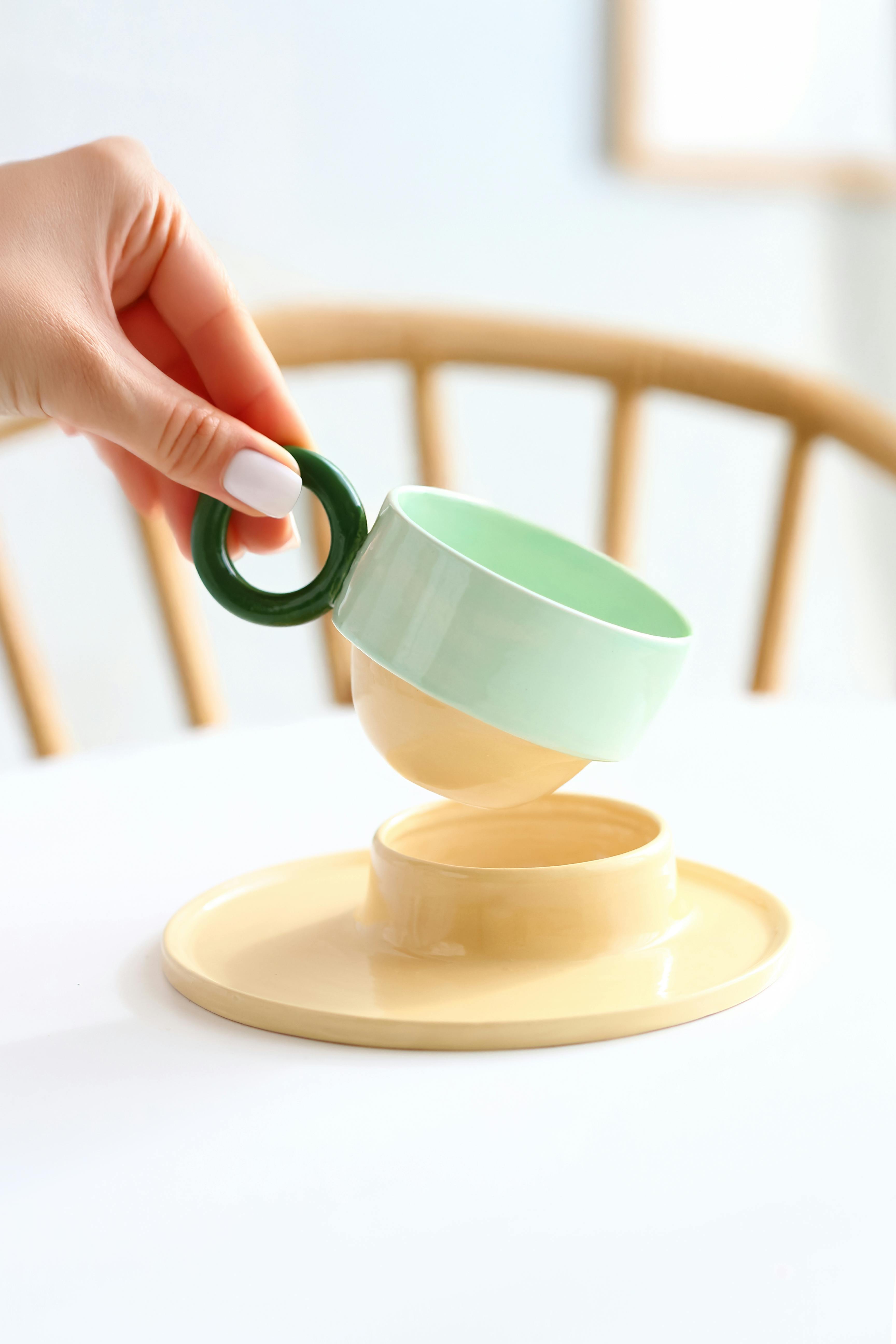 Colorful Modern Teacup Balancing on Saucer · Free Stock Photo