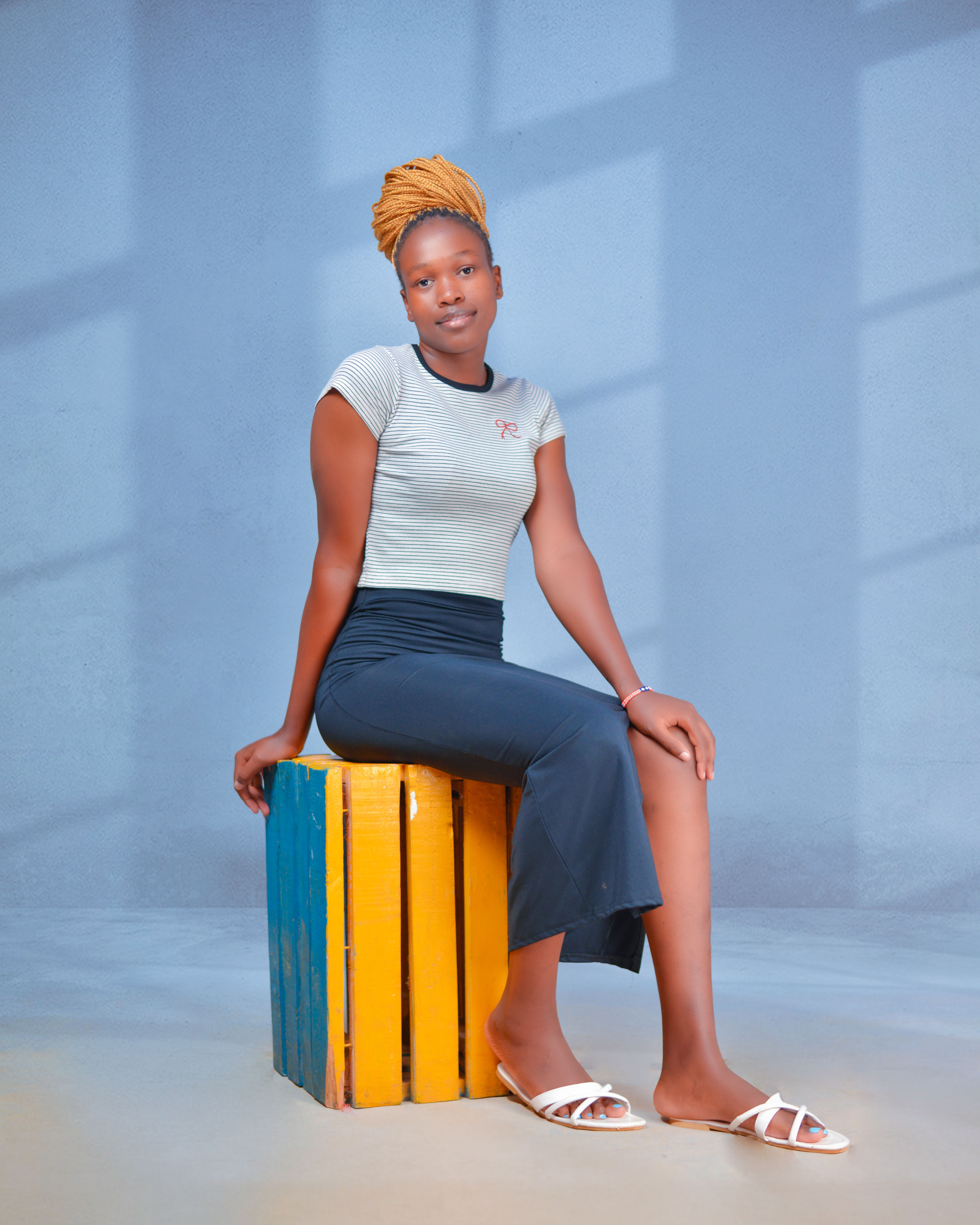 Portrait of Young Woman Seated on Vibrant Stool · Free Stock Photo