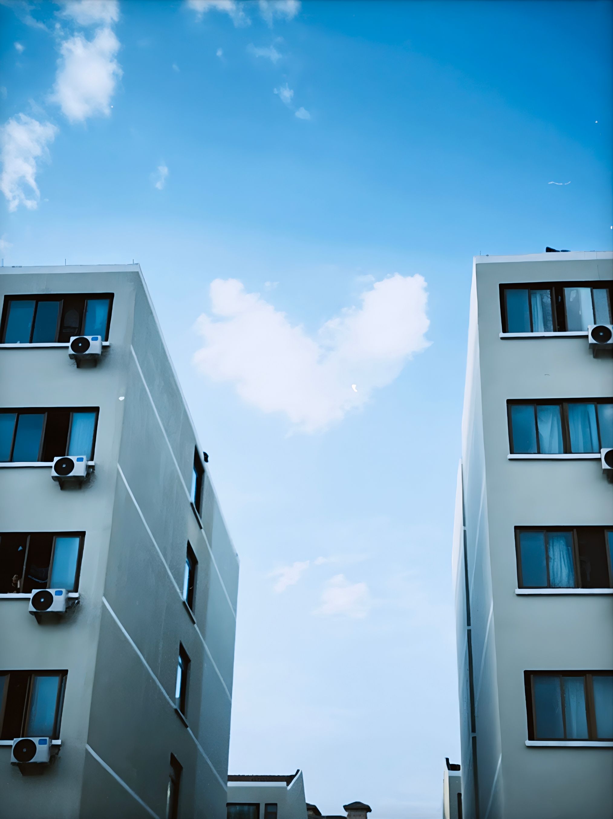Heart-Shaped Cloud Between Modern Buildings · Free Stock Photo