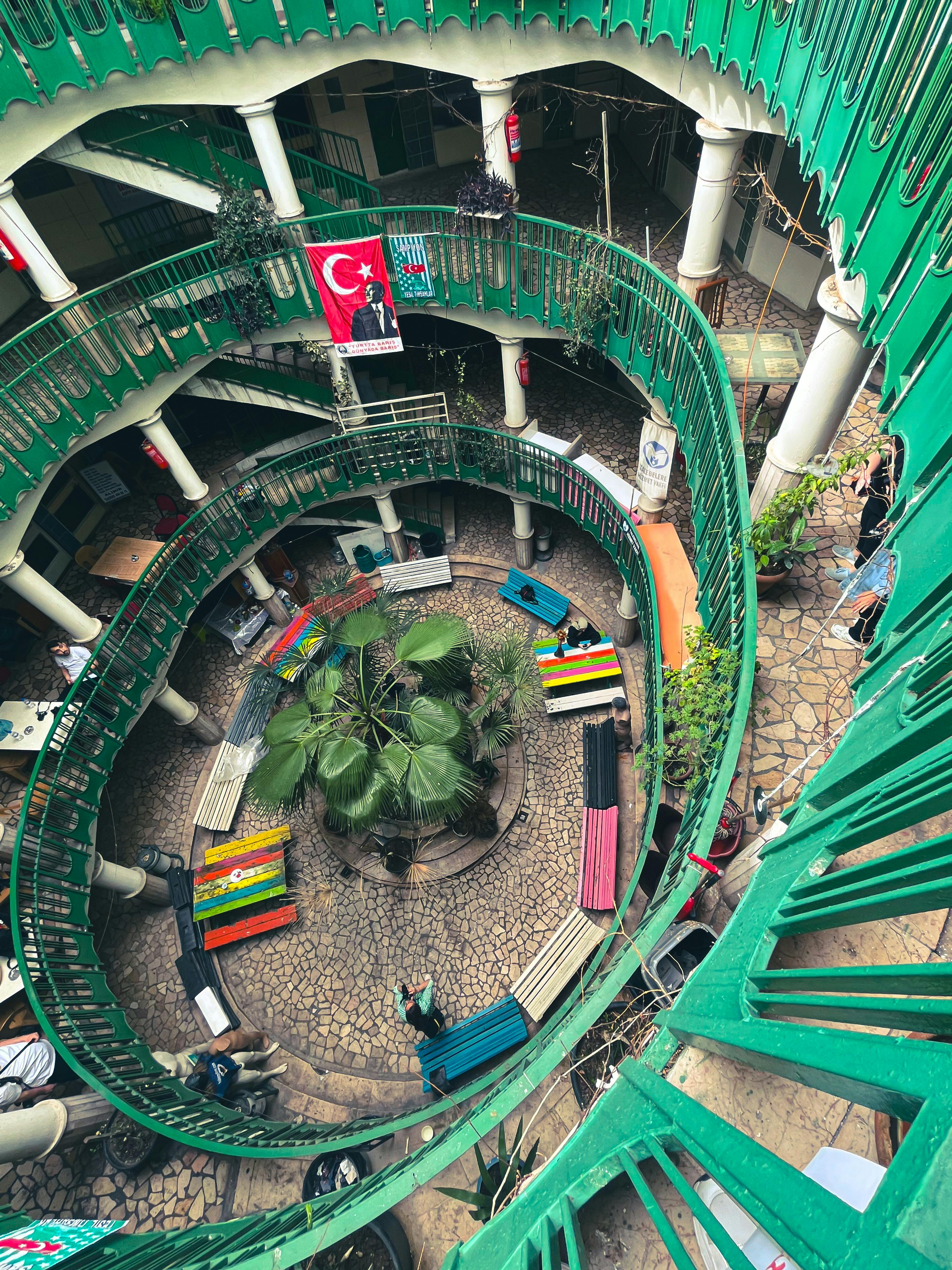 Colorful spiral atrium with greenery and flag · Free Stock Photo