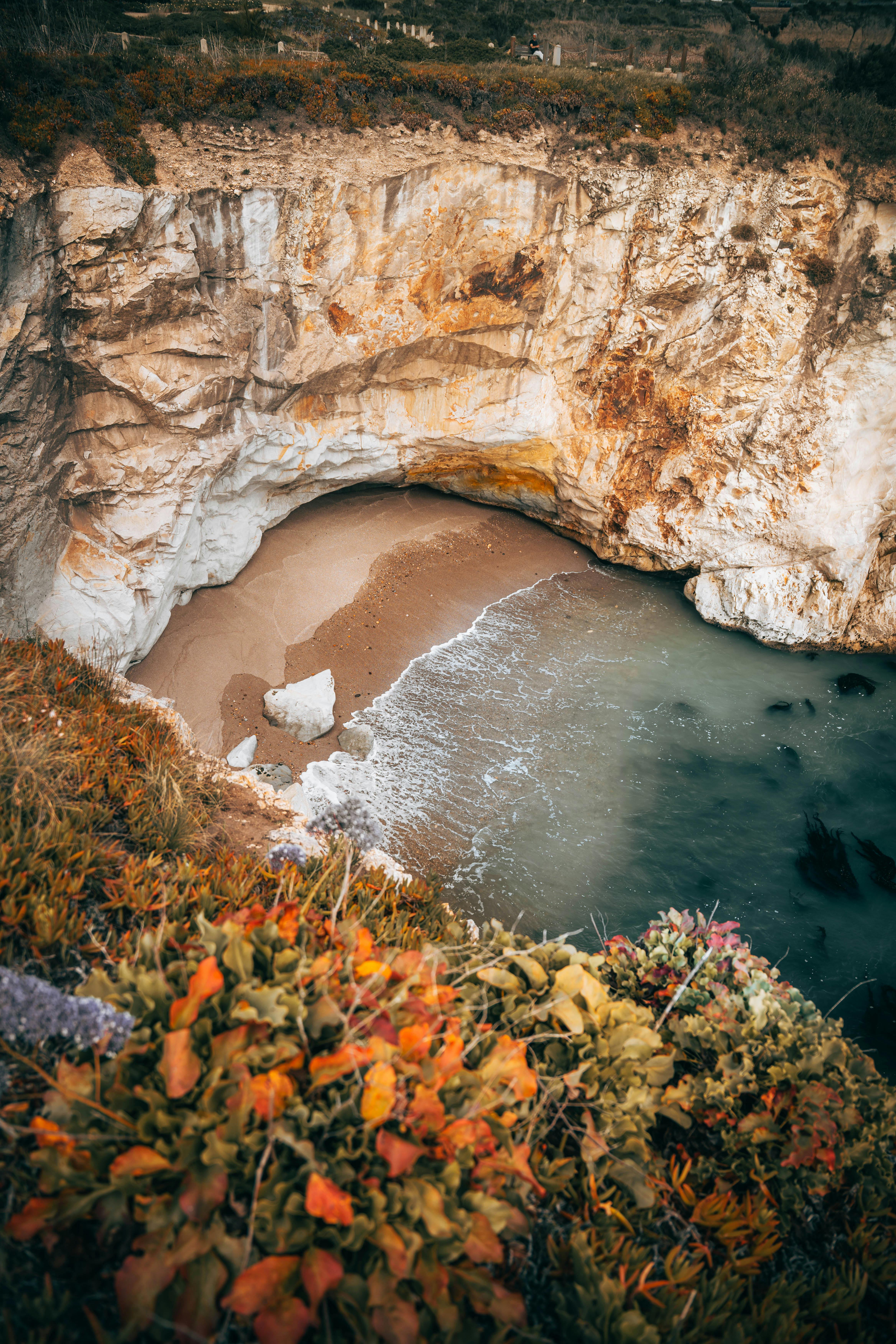 Scenic Coastal Beach Cove Surrounded by Cliffs · Free Stock Photo