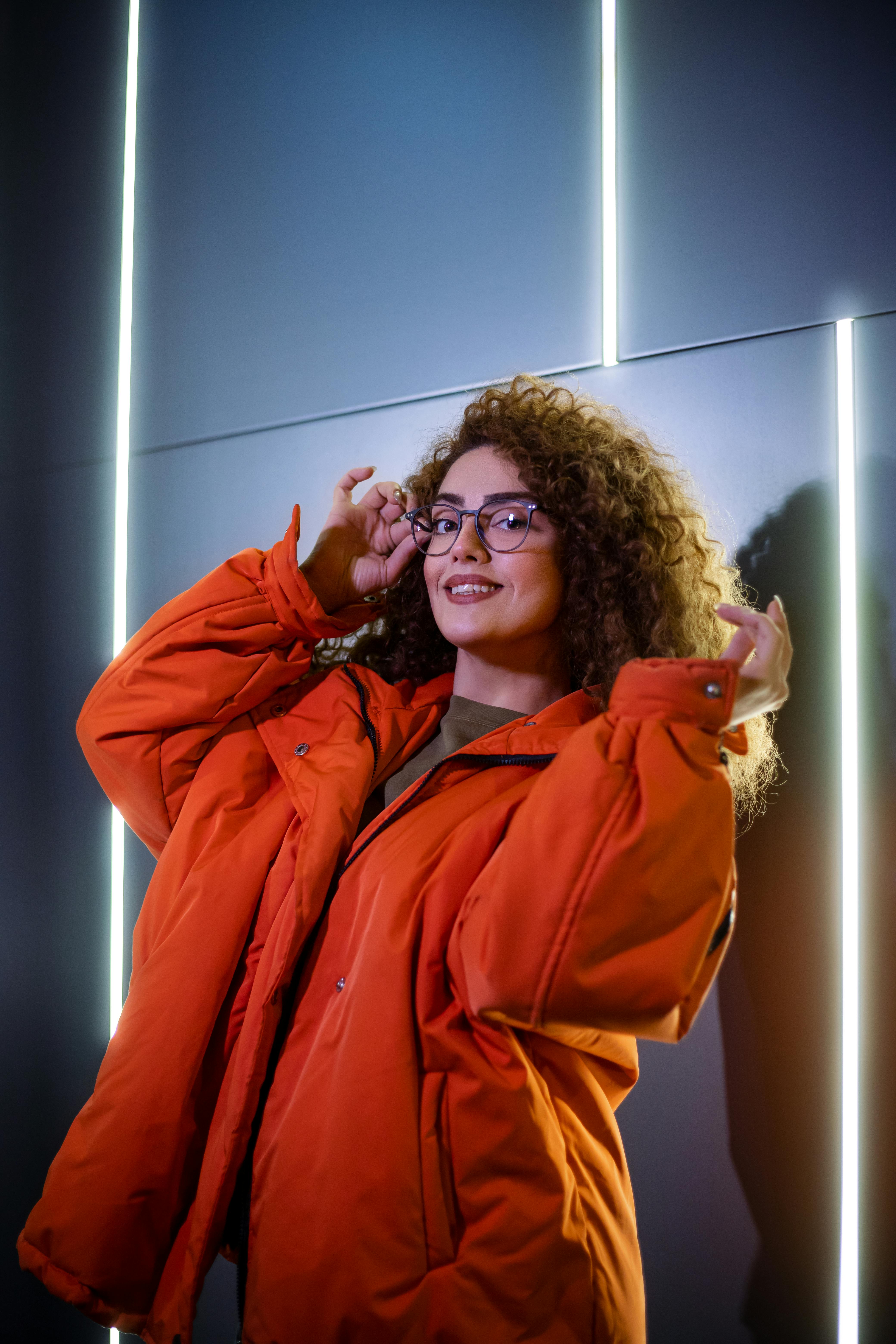Stylish Woman in Bright Orange Jacket Indoors · Free Stock Photo