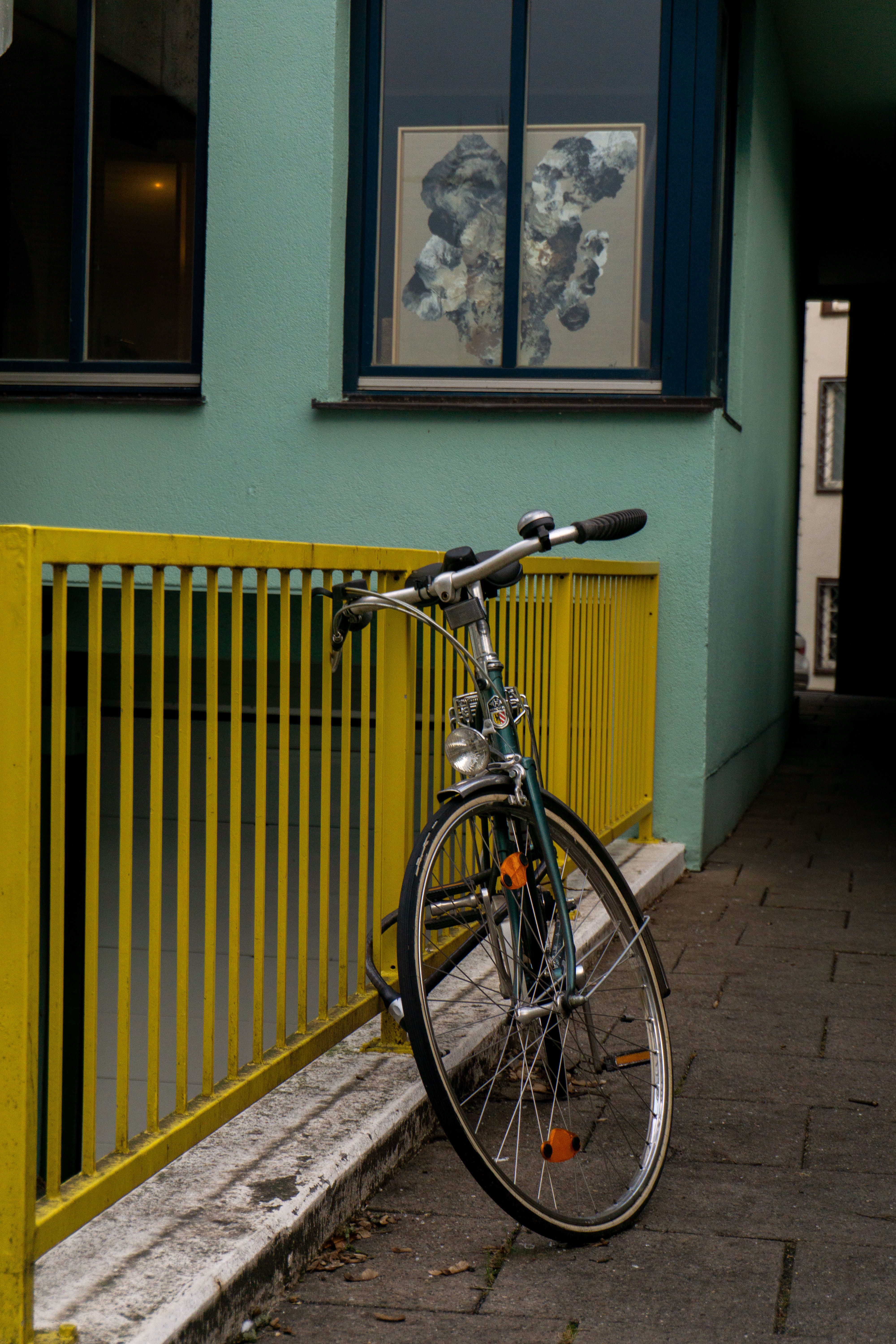 Urban Bicycle Resting Against Yellow Railings · Free Stock Photo