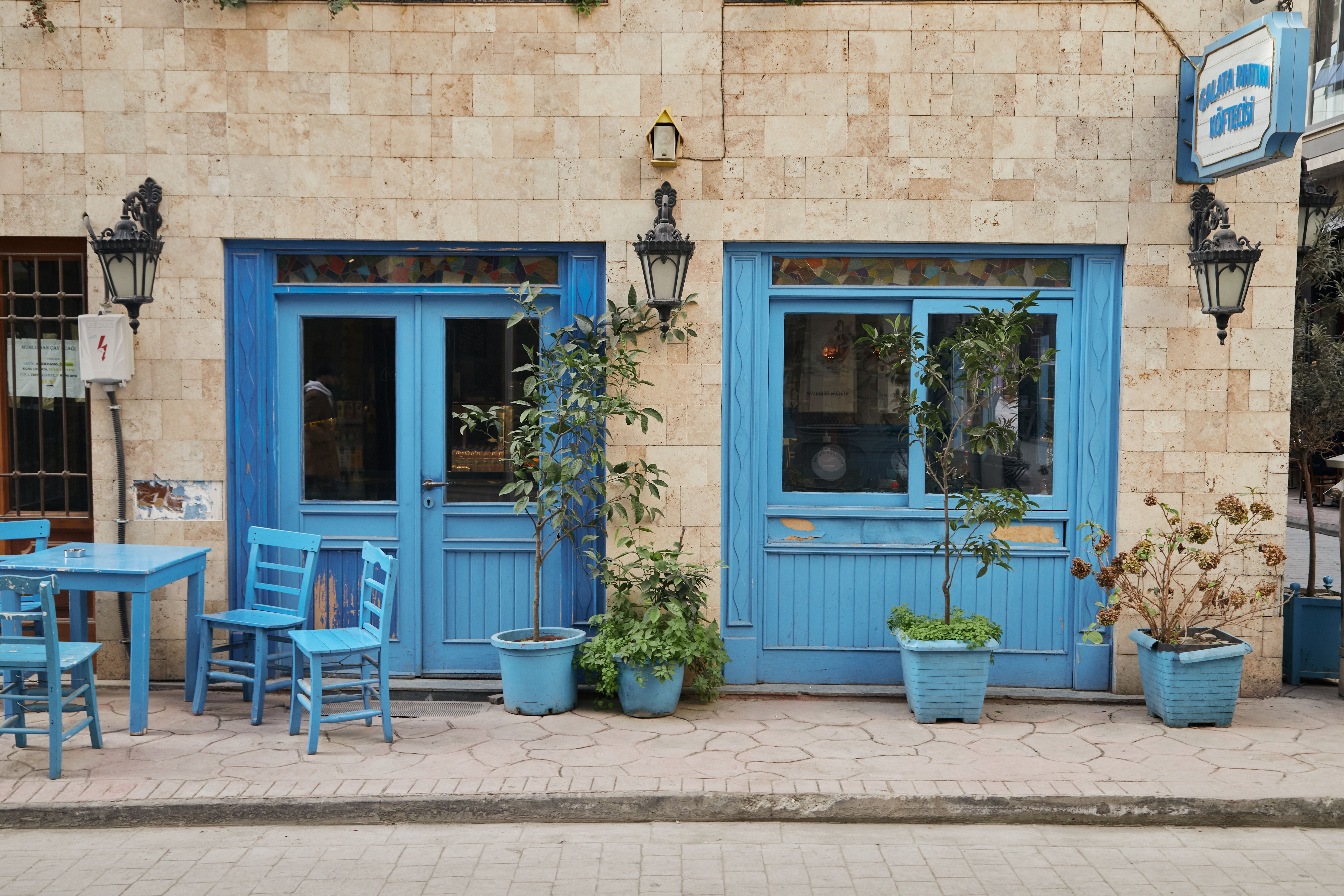 Charming Blue Café Facade with Outdoor Seating · Free Stock Photo