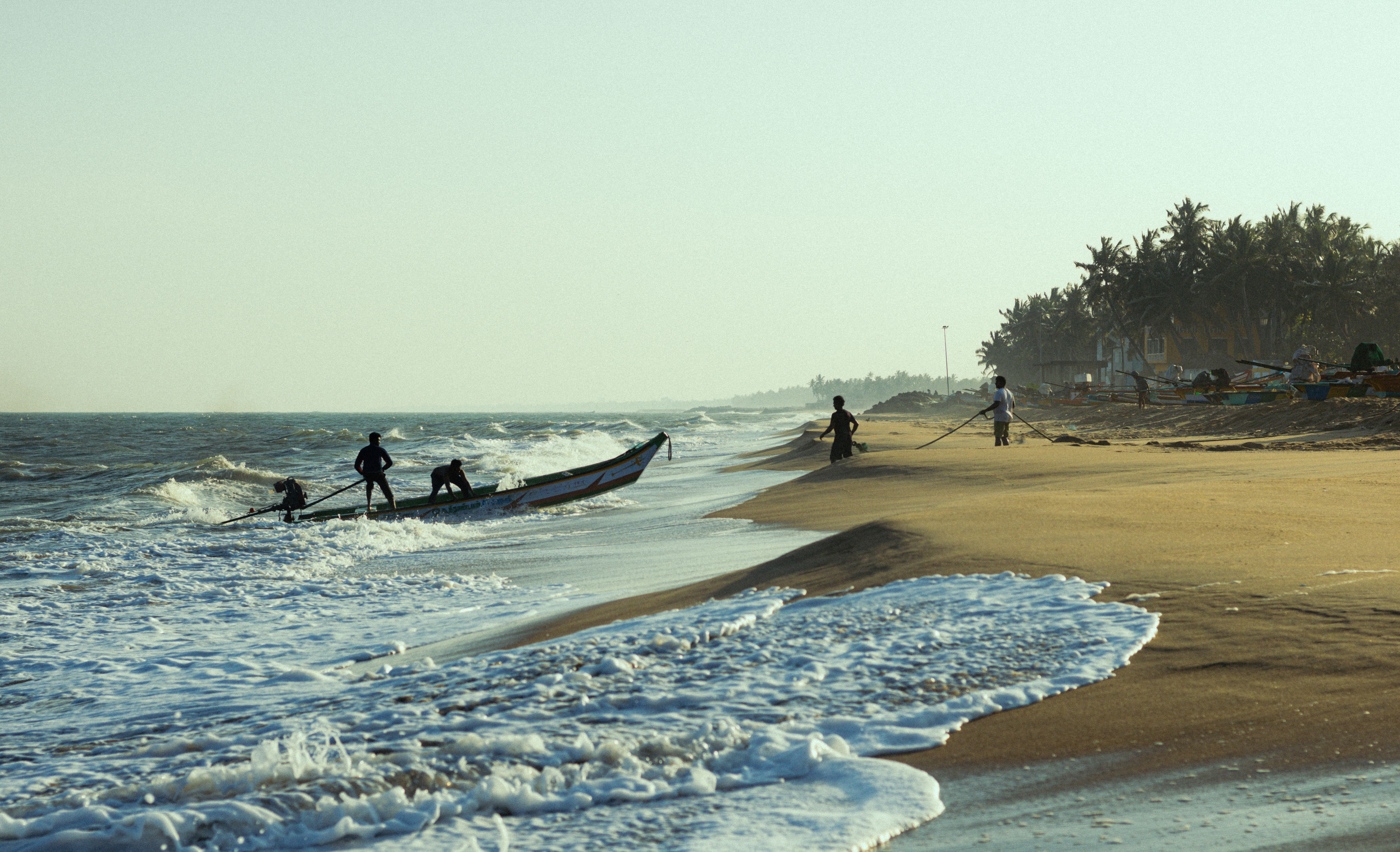 Fishermen Launching Boat on Puducherry Beach at Sunset · Free Stock Photo