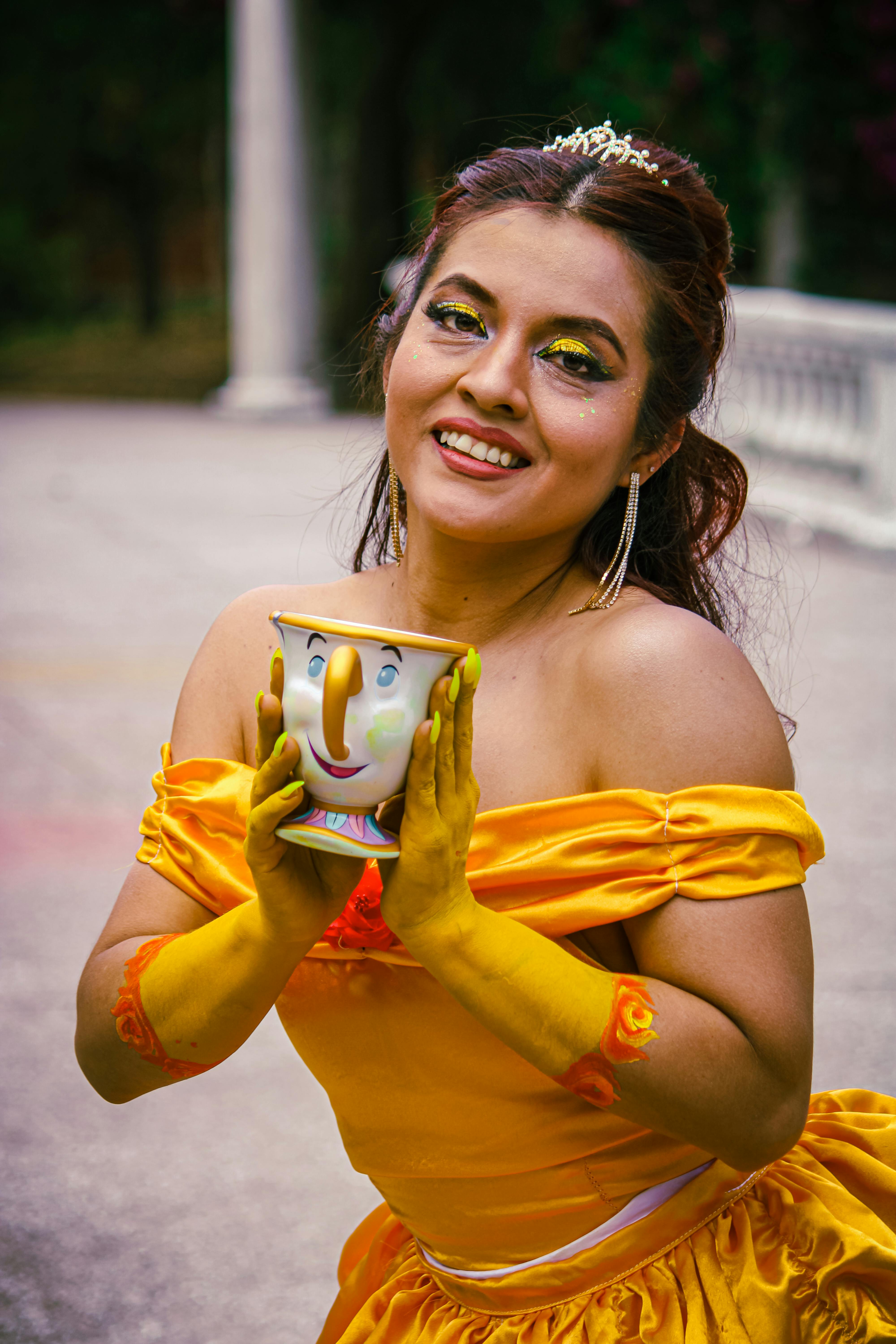 Woman in Yellow Costume Holding Decorative Mug · Free Stock Photo