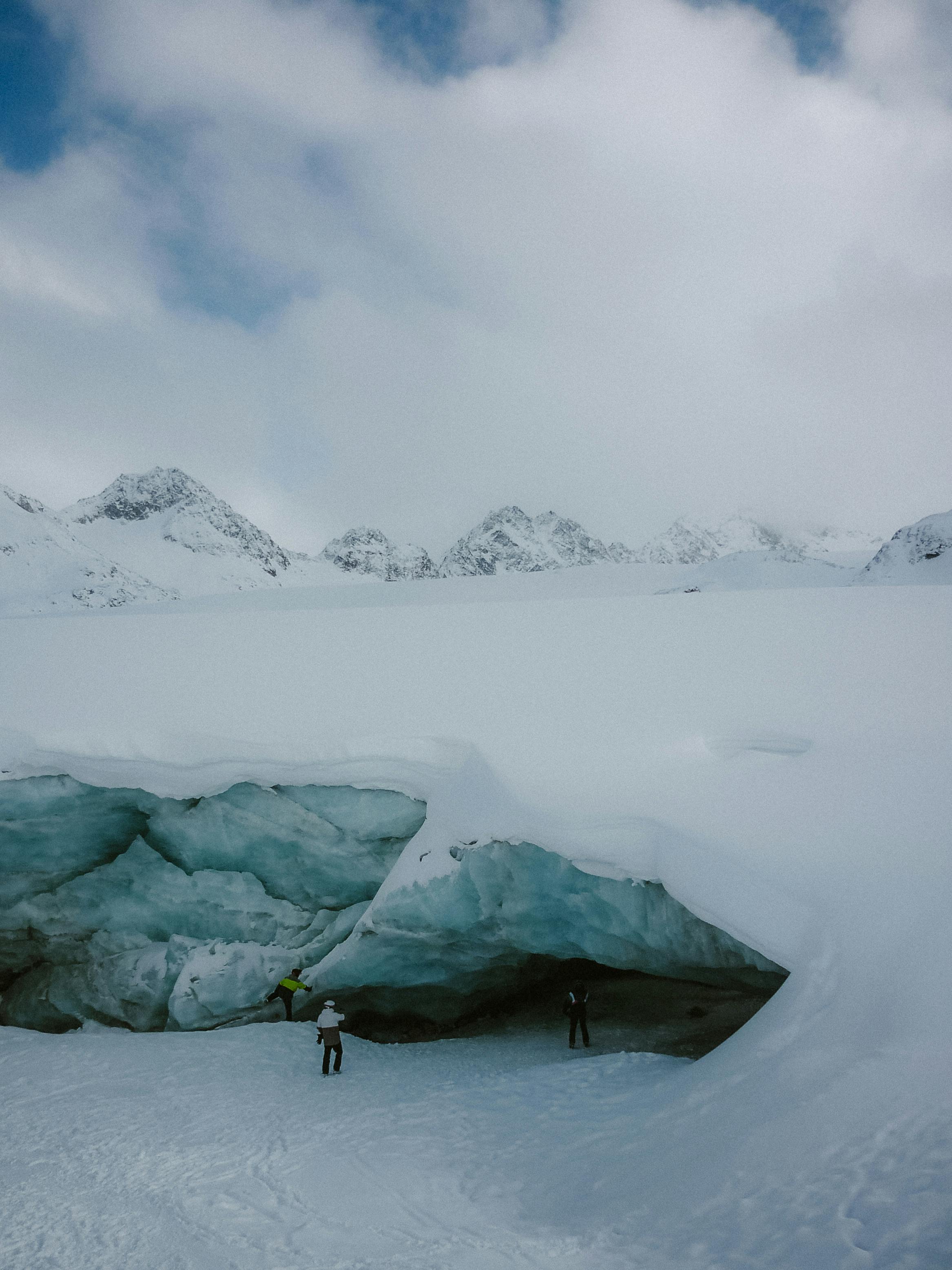 Explorers Entering a Majestic Ice Cave in Winter · Free Stock Photo
