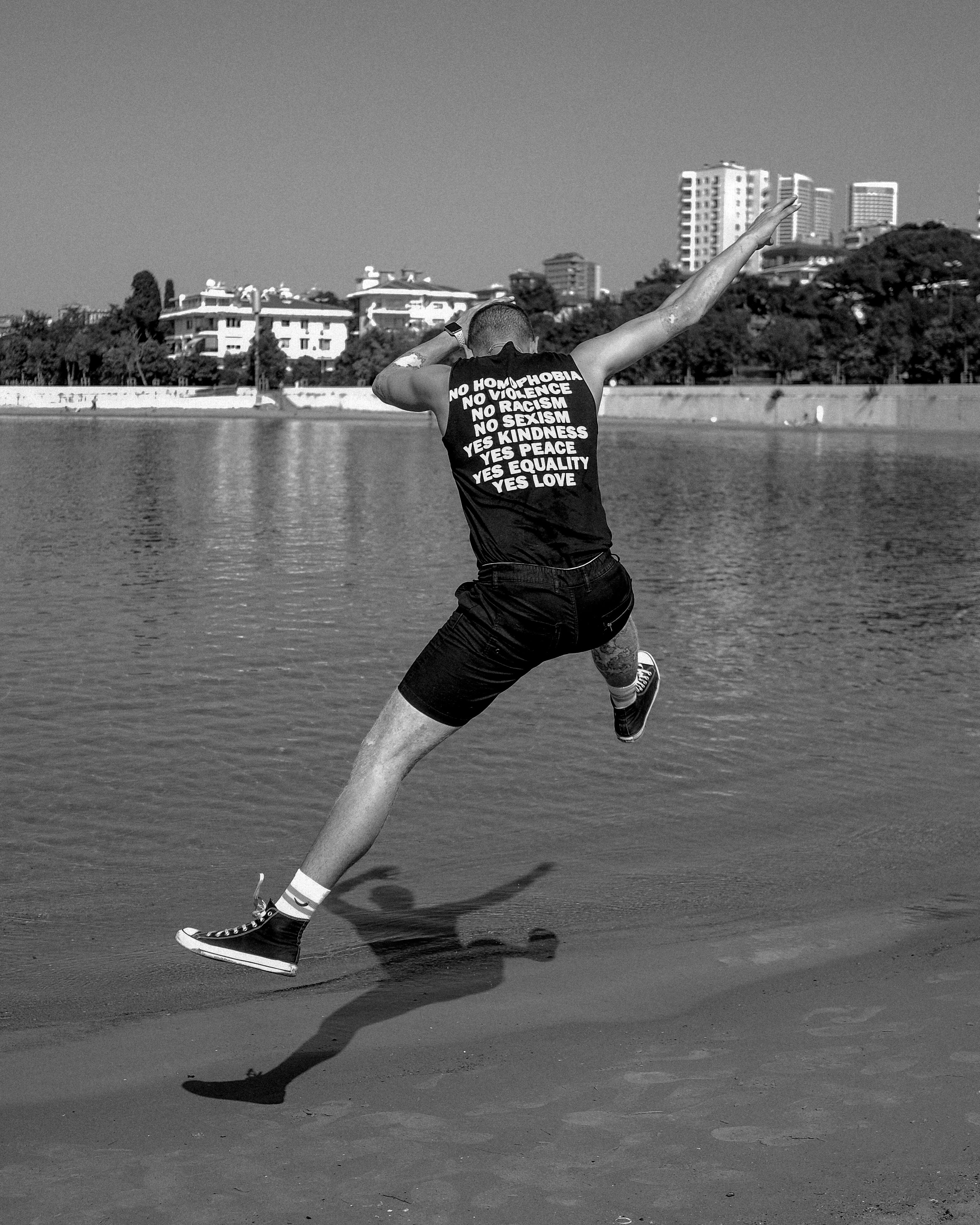 Man Dabbing in Mid Air Above Body of Water during Day · Free Stock Photo