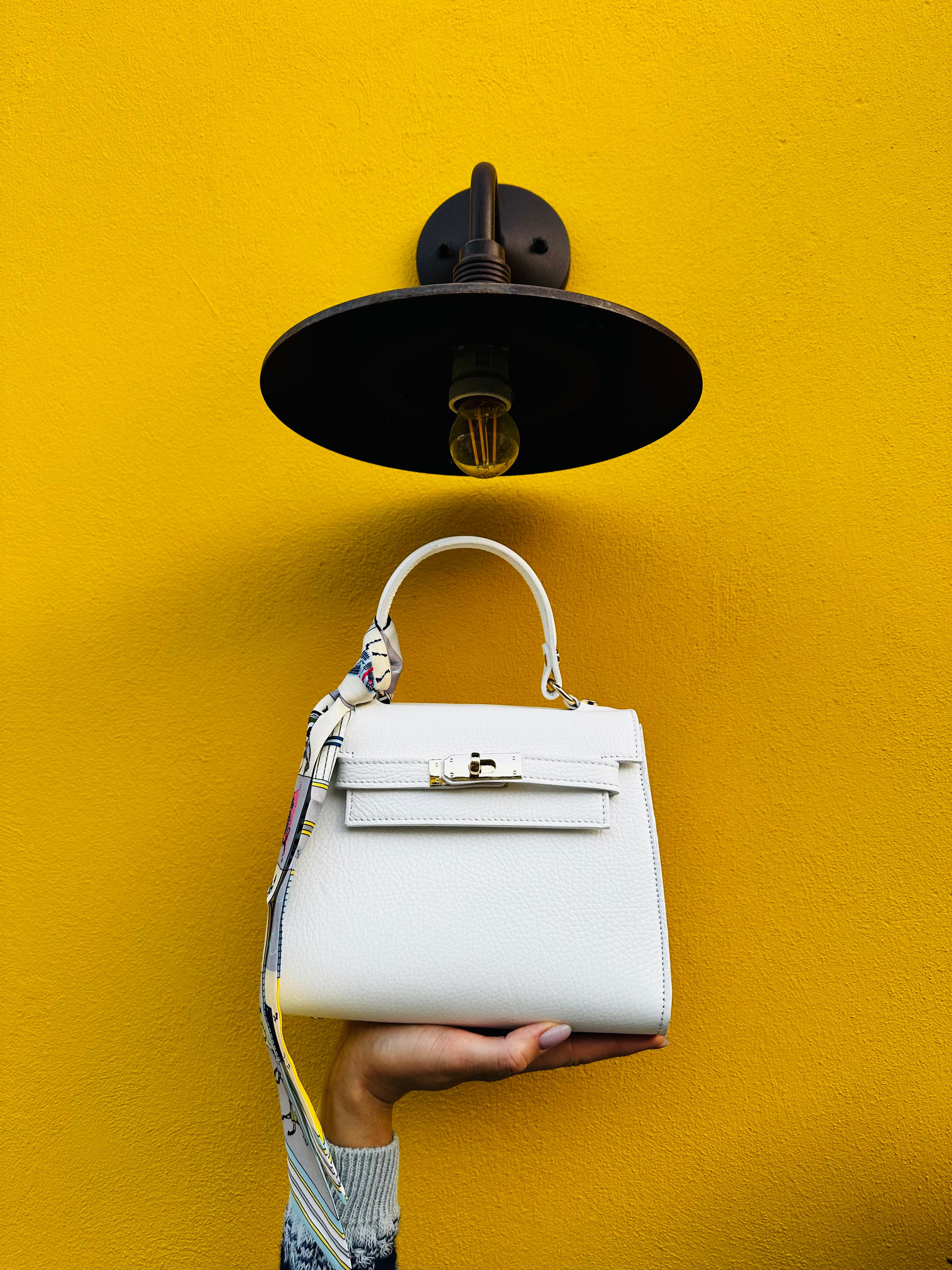 Elegant White Handbag Against Yellow Wall · Free Stock Photo