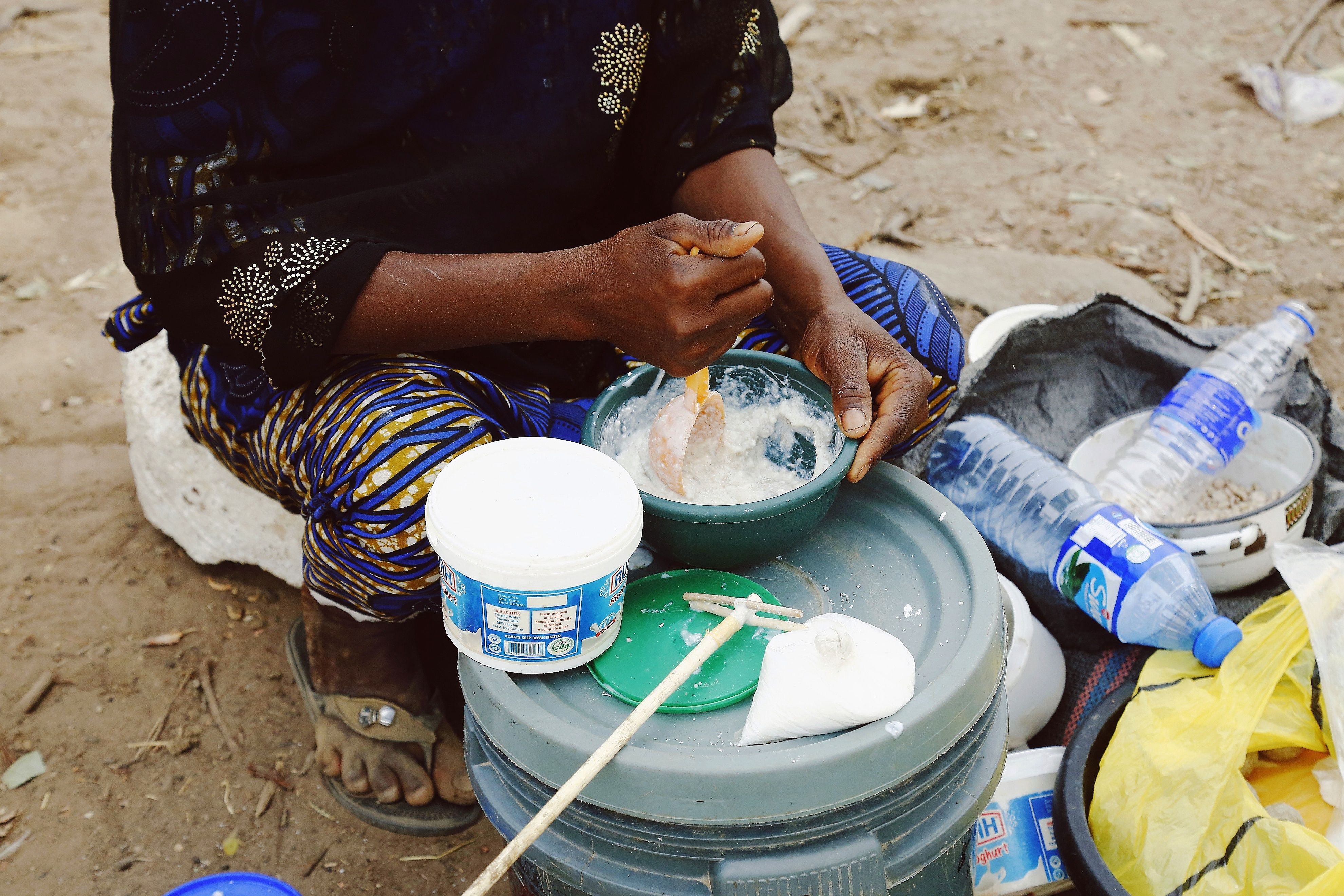 African woman cooking traditional food outdoors · Free Stock Photo