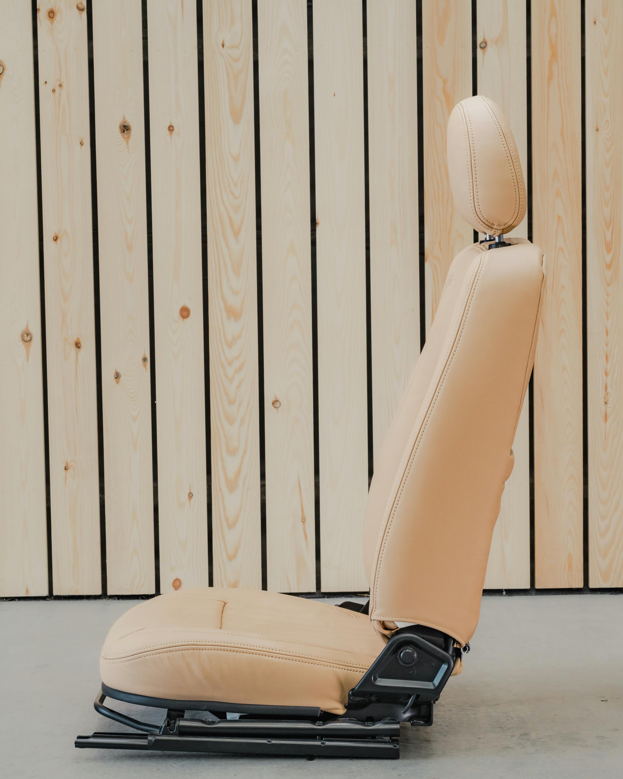 Tan Leather Car Seat Against Wooden Background · Free Stock Photo