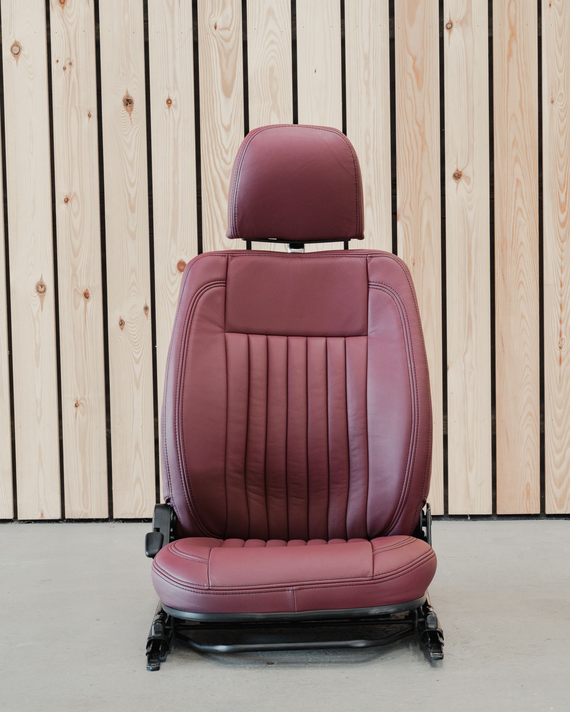 Elegant Burgundy Leather Car Seat Against Wooden Panel · Free Stock Photo