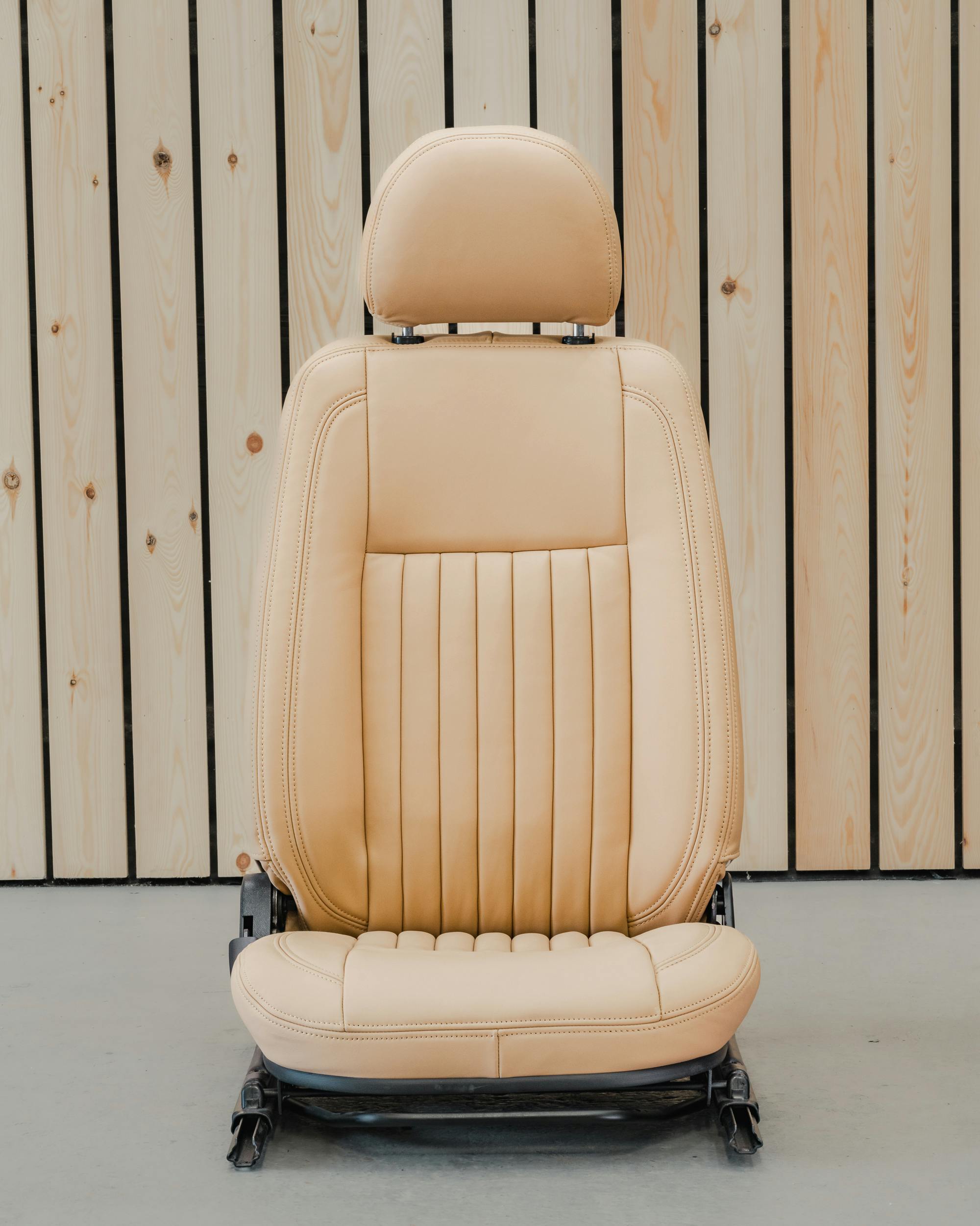 Elegant Tan Leather Car Seat Against Wooden Paneling · Free Stock Photo