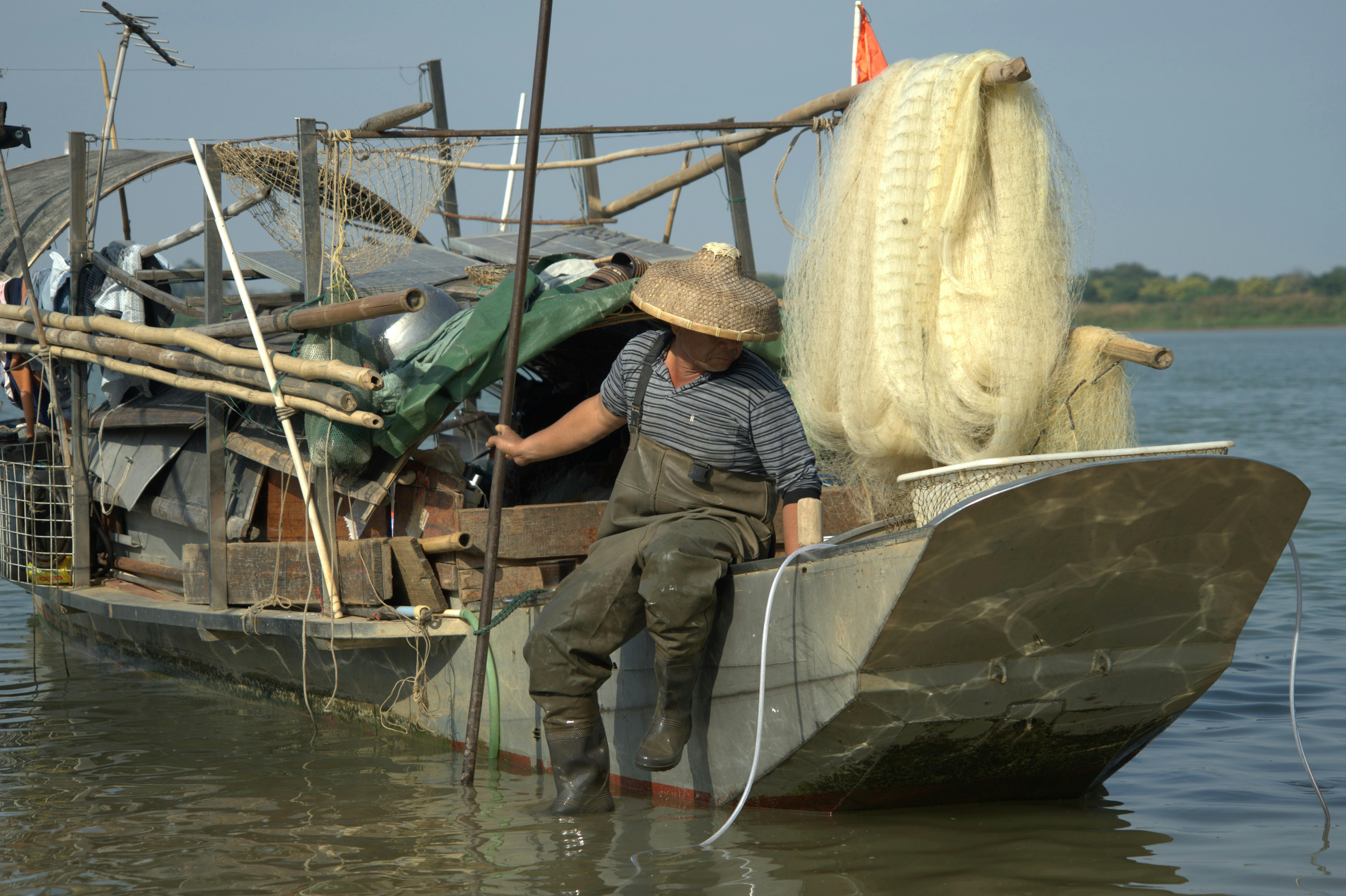 Pescador Tradicional En Barco Rústico Con Red · Foto de stock gratuita