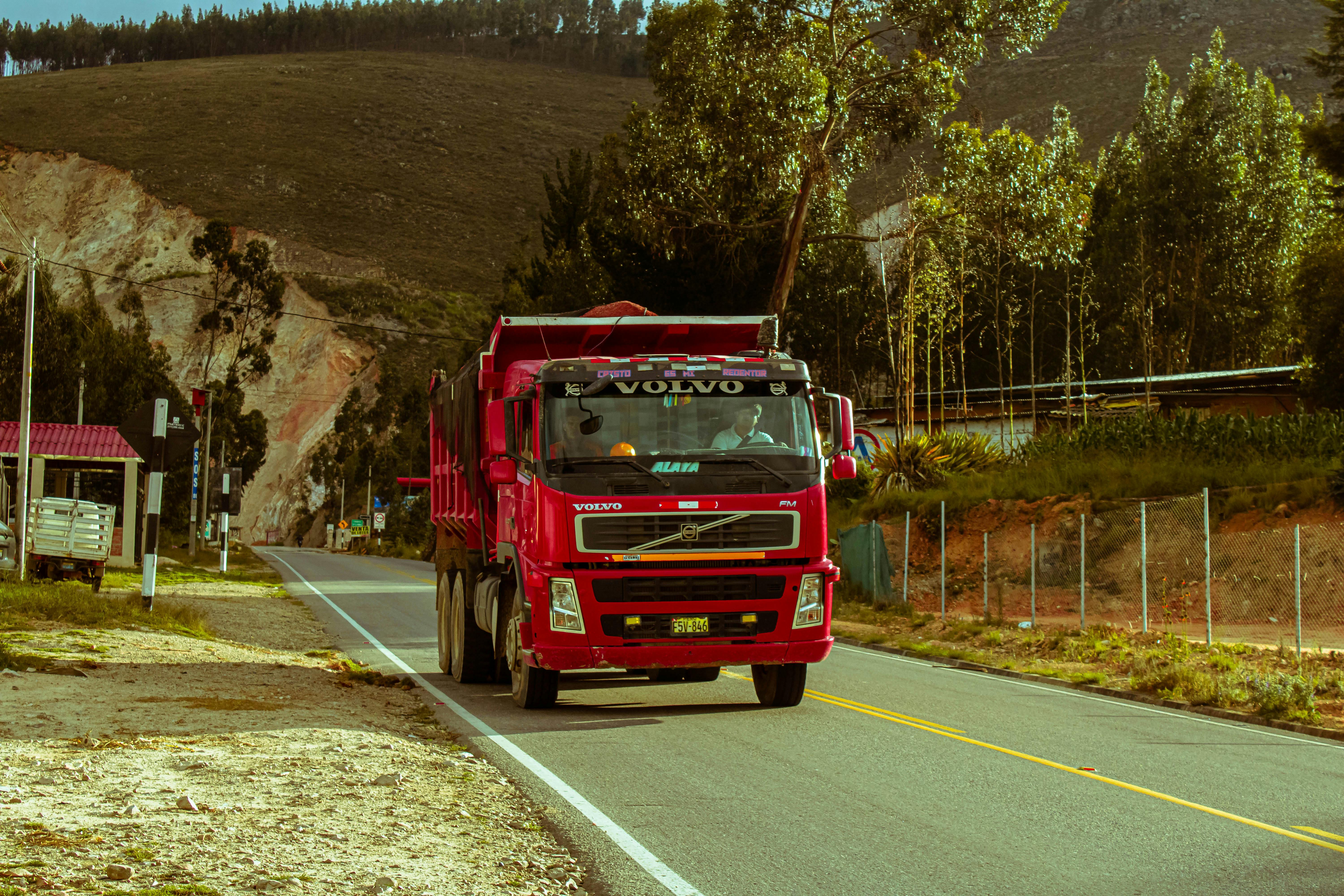 Red Volvo Truck Driving on a Scenic Mountain Road · Free Stock Photo