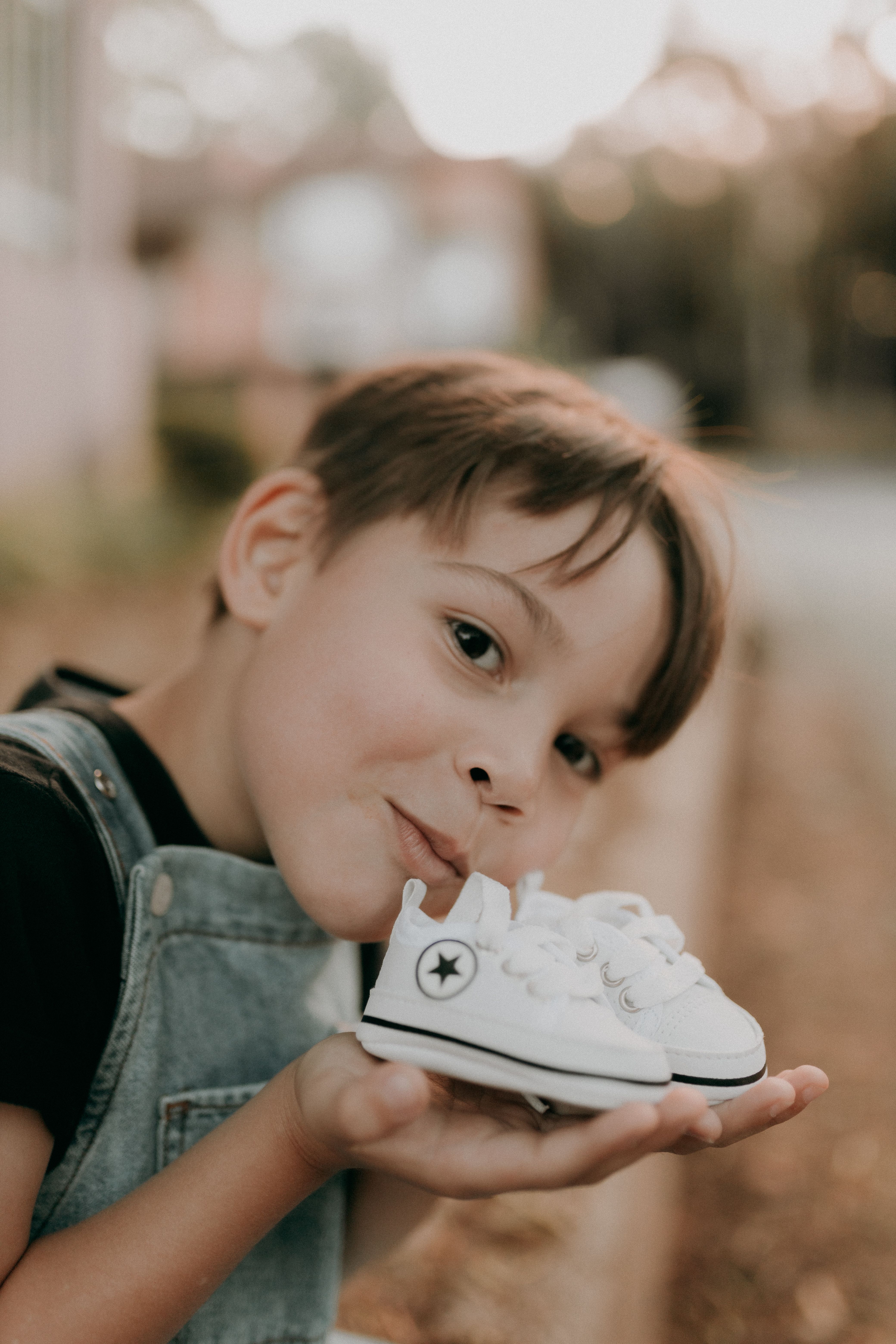 Cute child with baby shoes outdoors · Free Stock Photo