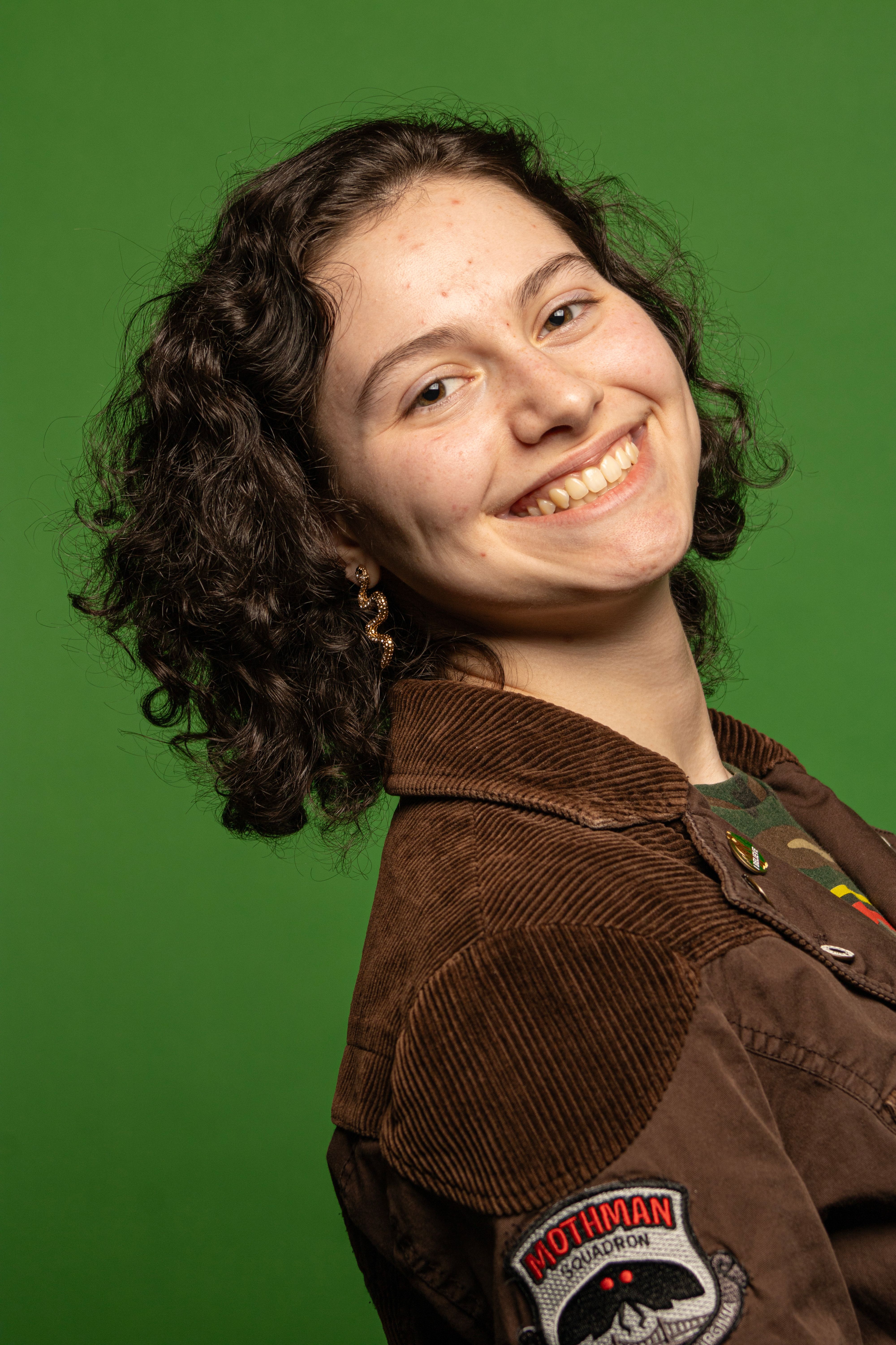 Cheerful Young Woman Posing with Green Background · Free Stock Photo