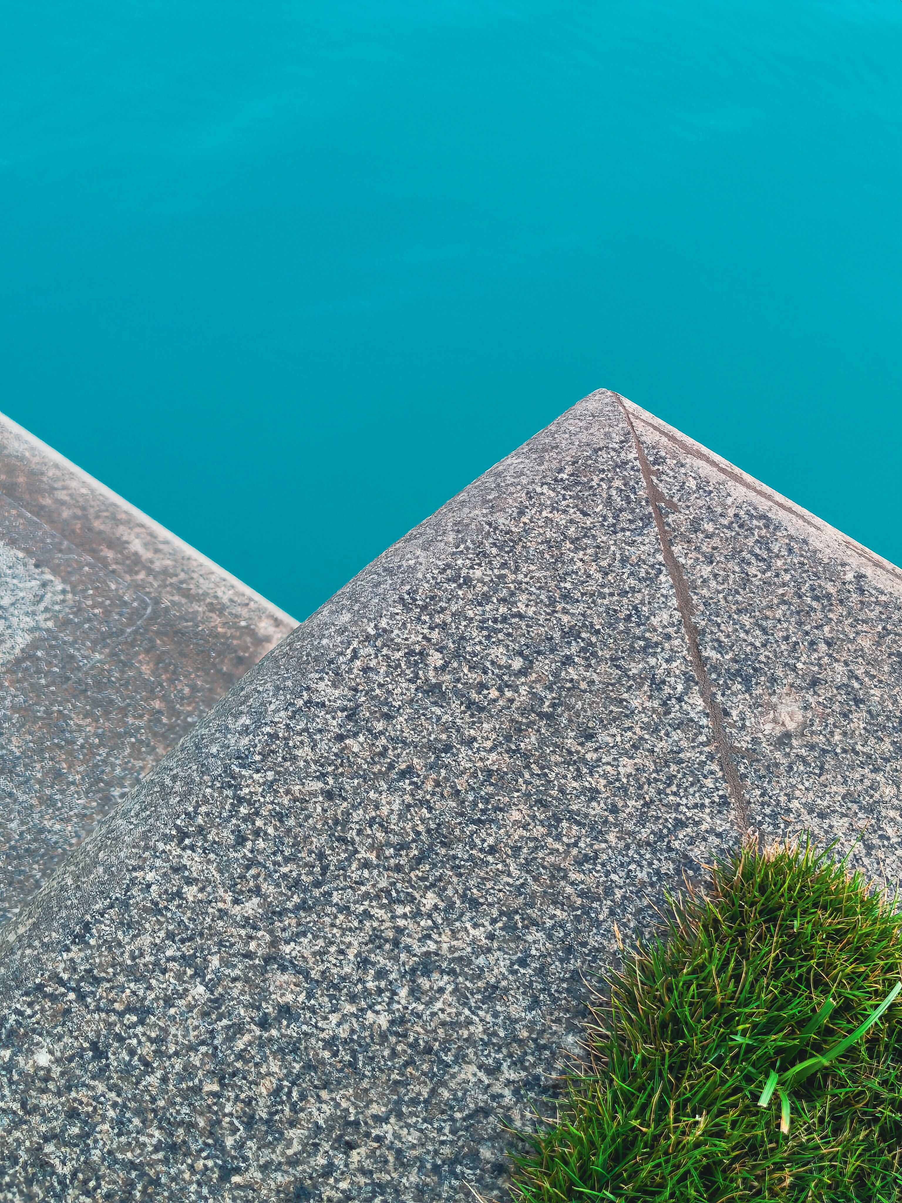 Geometric Stone Ledge Overlooking Blue Water · Free Stock Photo