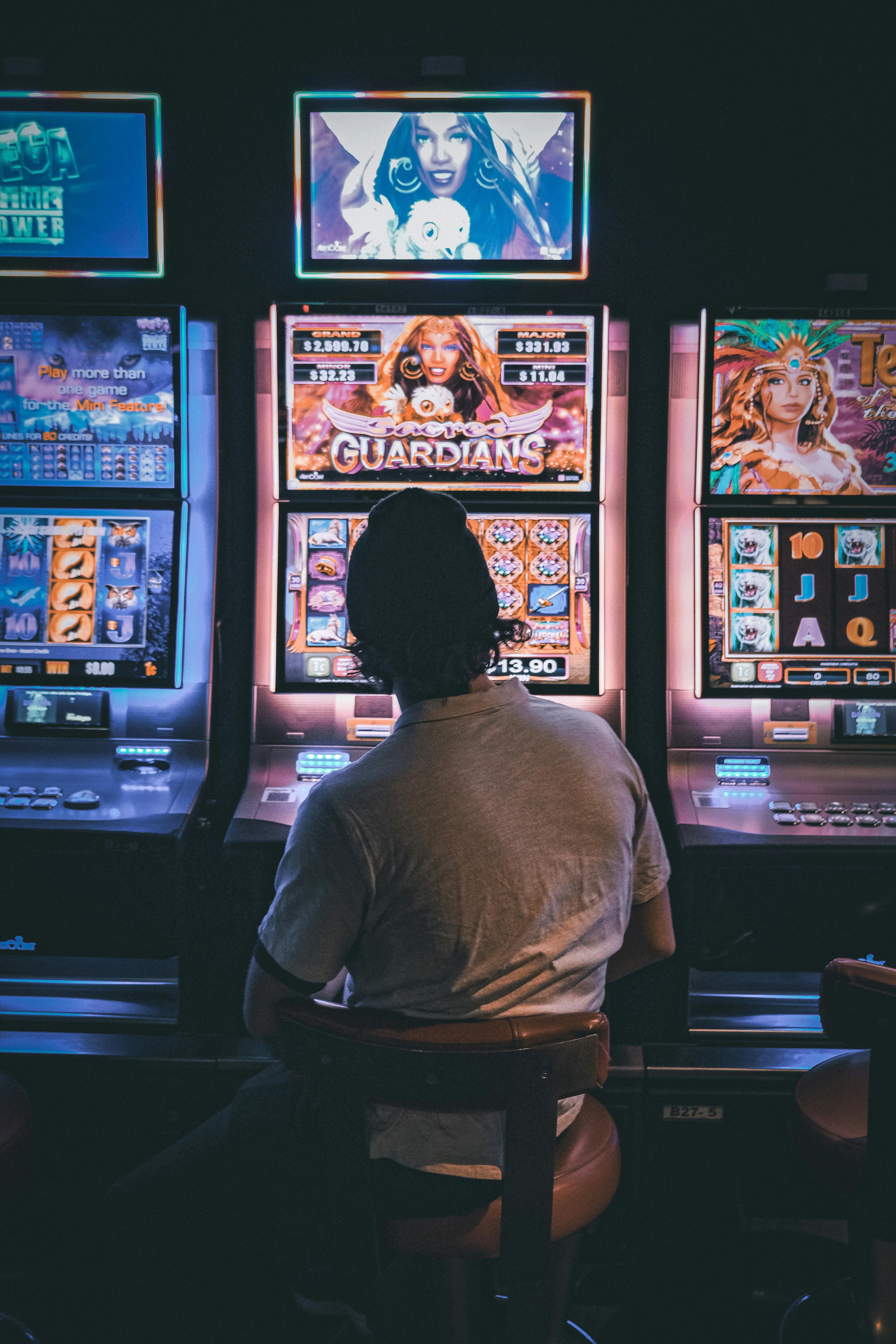 Man Enjoying Slot Machines in Casino · Free Stock Photo
