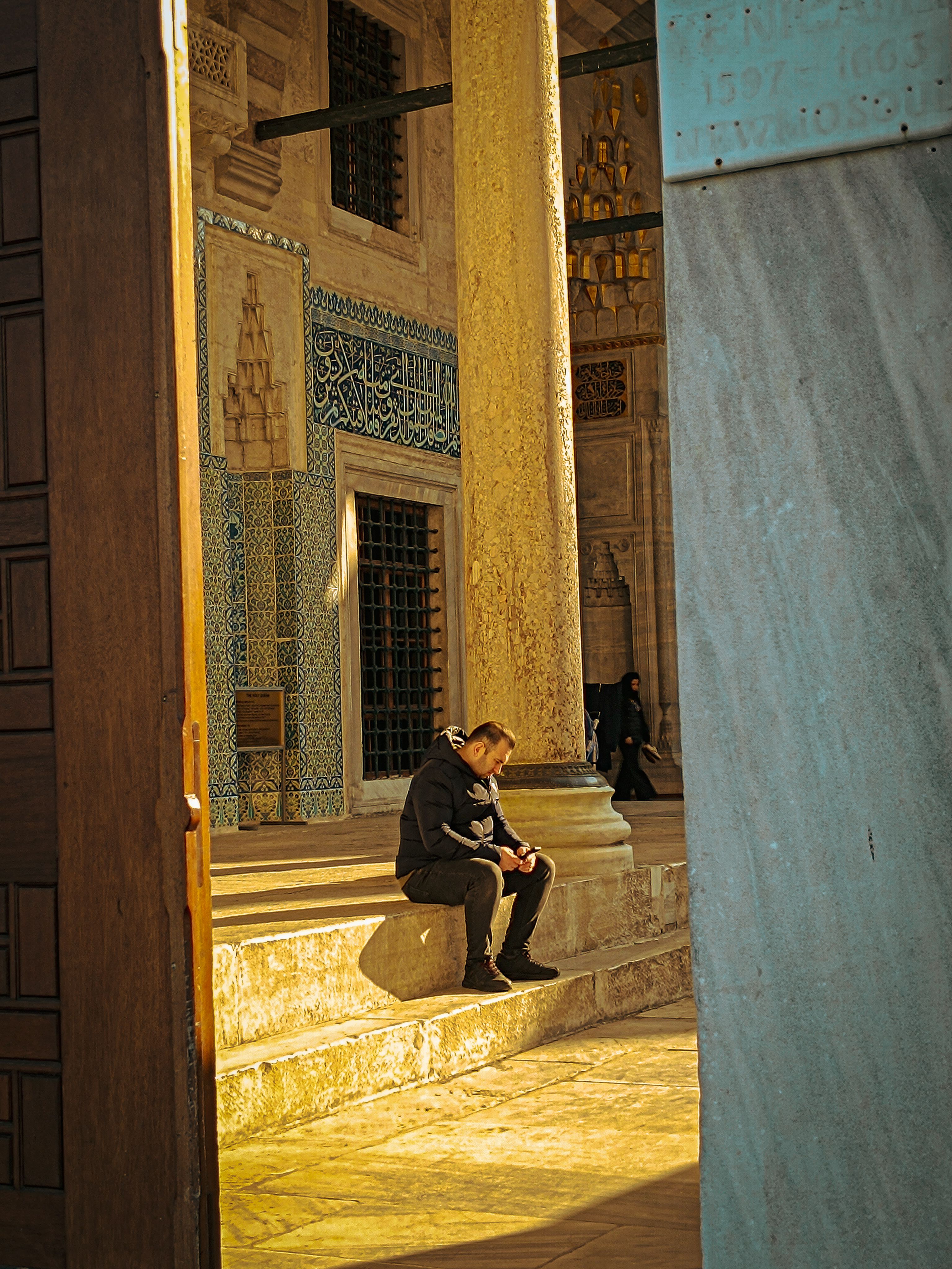 Man Sitting in a Historic Architectural Setting · Free Stock Photo