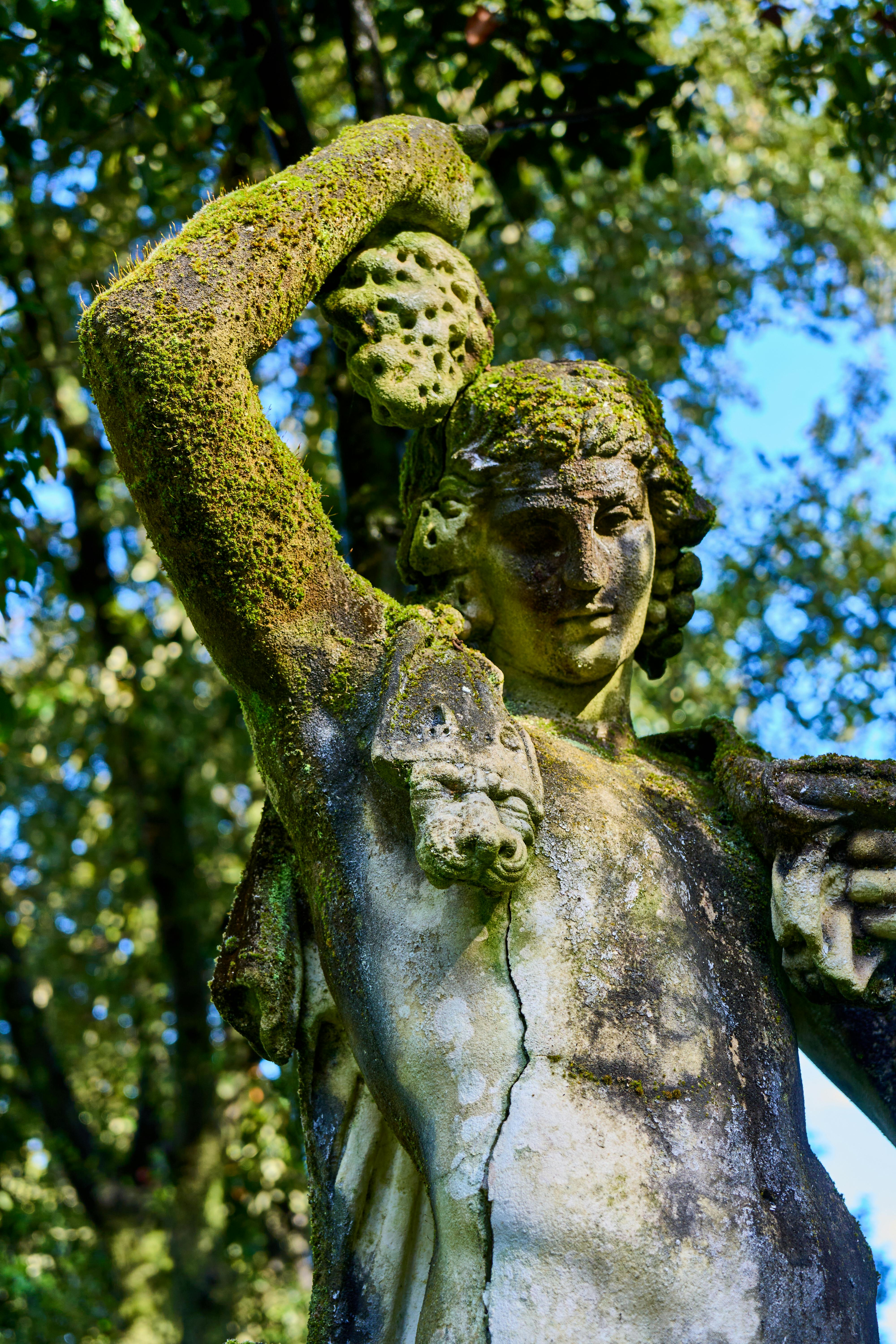 Ancient Moss-Covered Stone Statue · Free Stock Photo