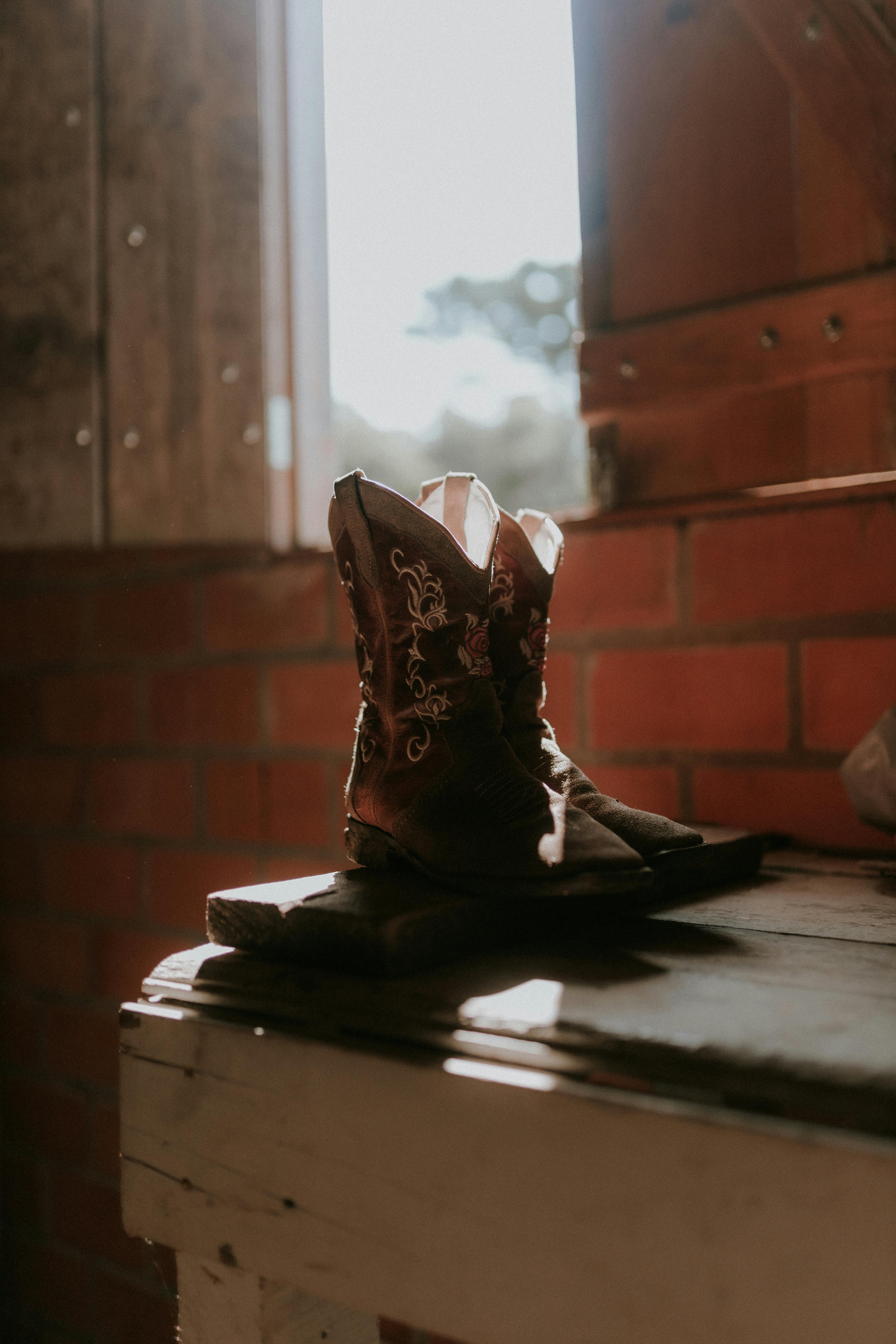 Rustic Cowboy Boots in Sunlit Barn · Free Stock Photo