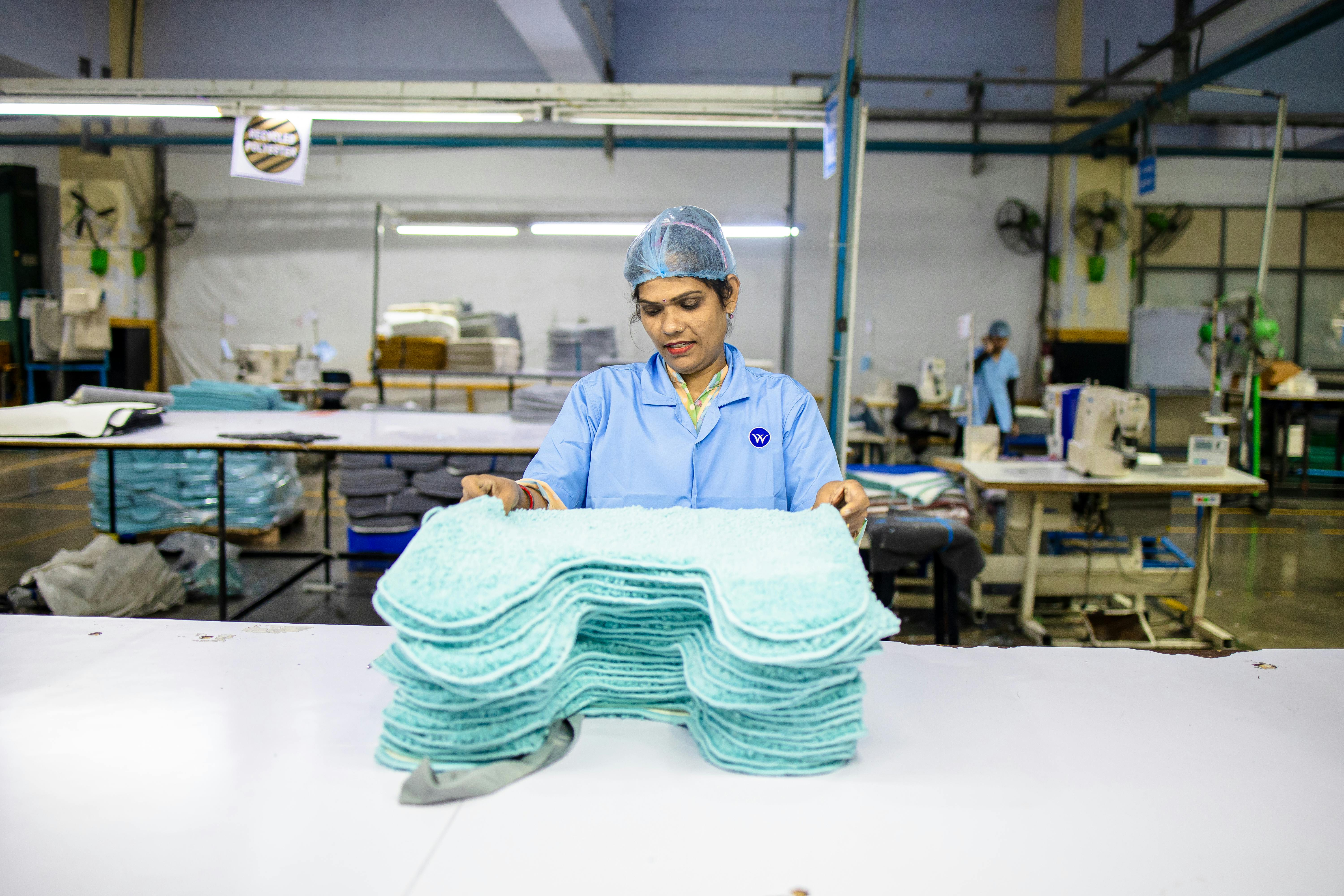 Blue Collar Worker in Textile Factory Sorting Fabrics · Free Stock Photo