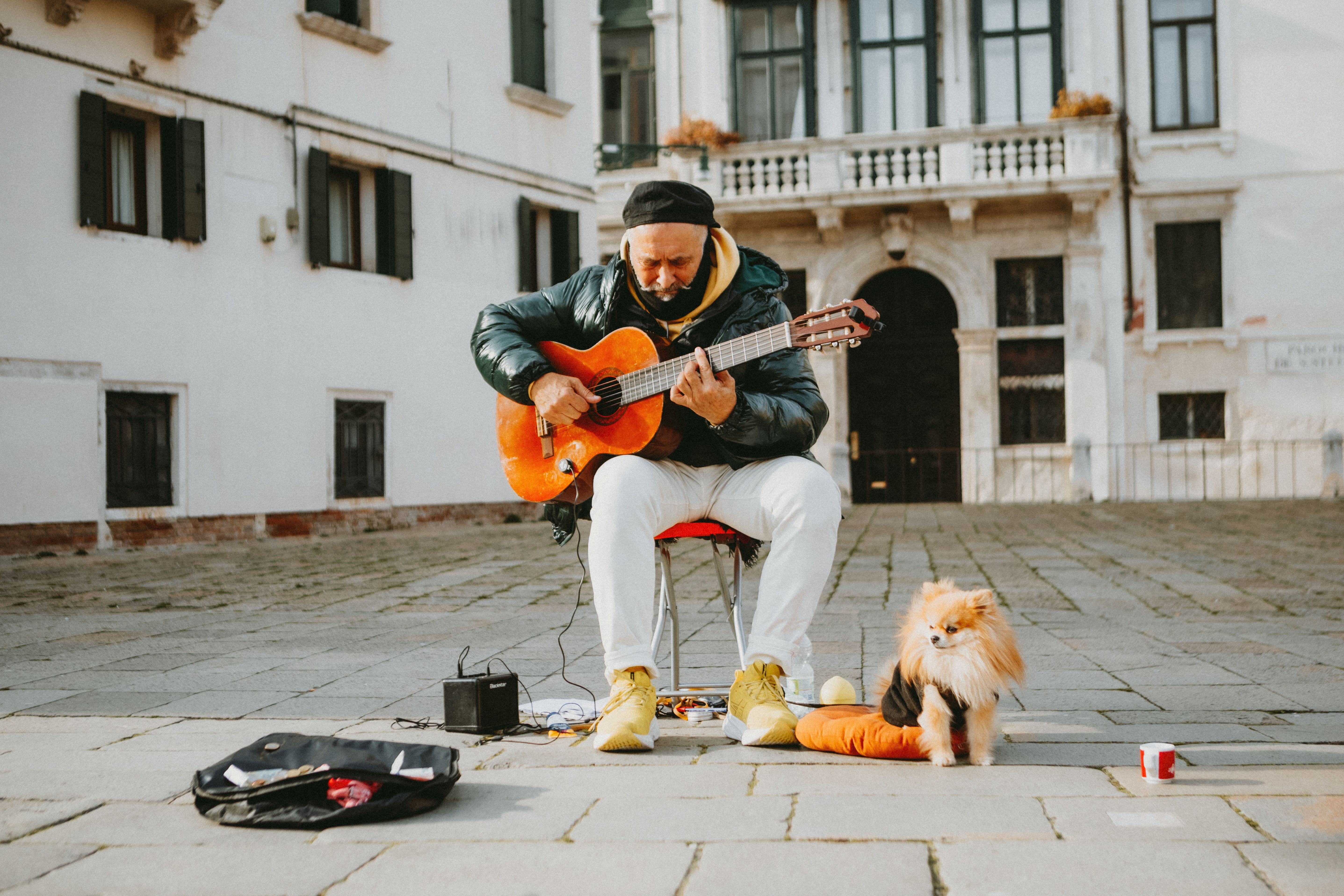 Street Musician Playing Guitar with Dog Companion · Free Stock Photo