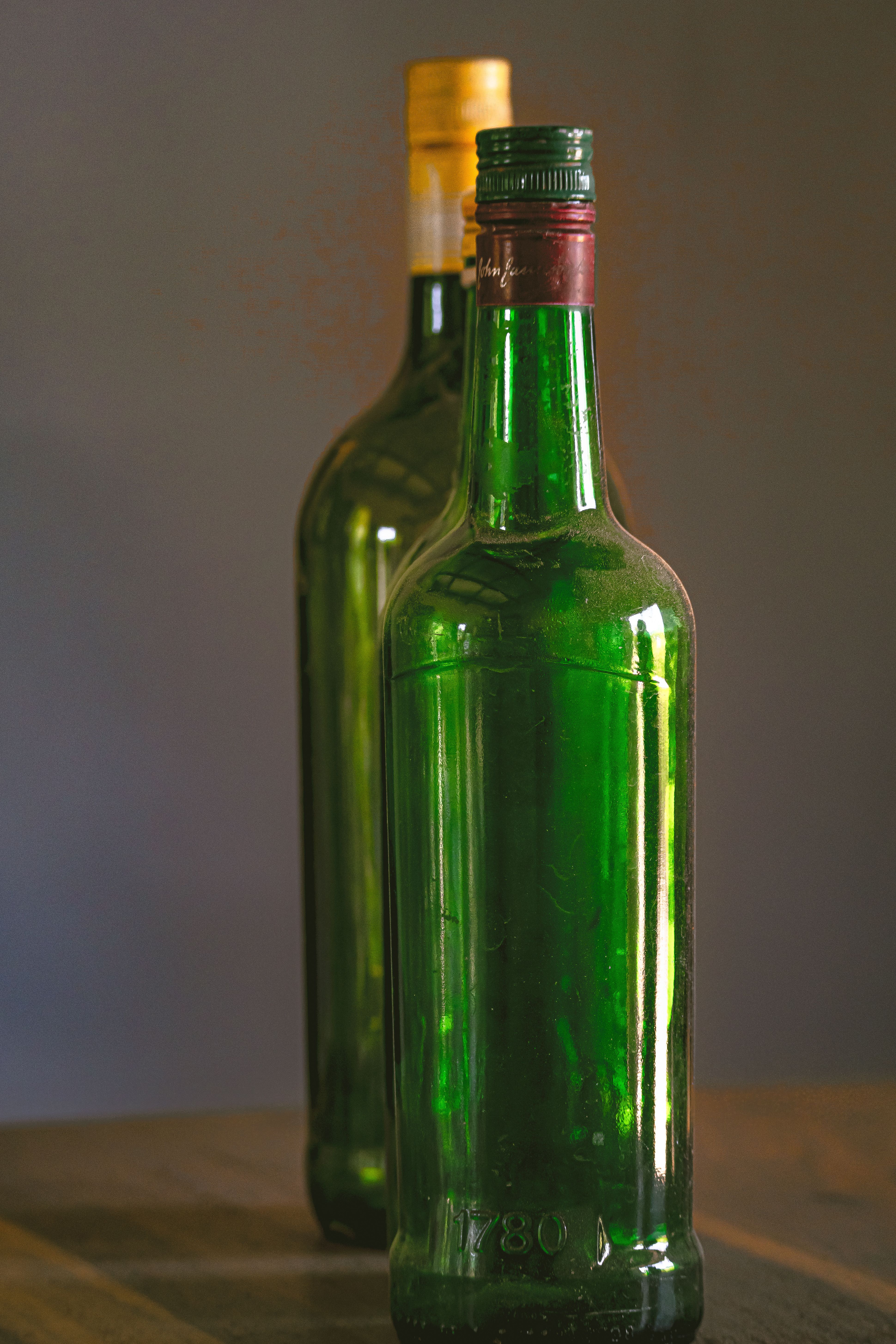 Close-Up of Vintage Green Wine Bottles Indoors · Free Stock Photo