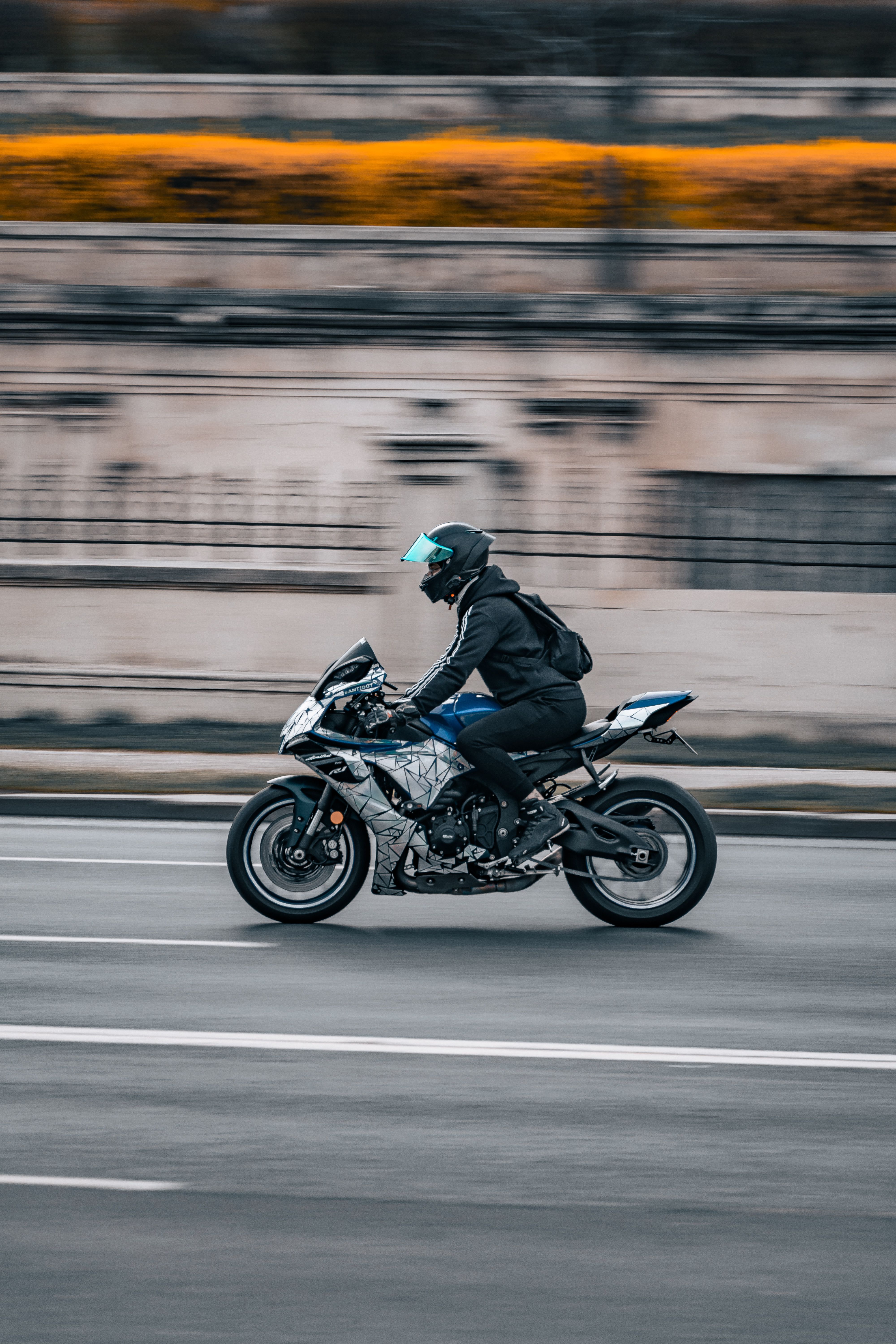 Motorcyclist Riding Fast on Urban Road · Free Stock Photo