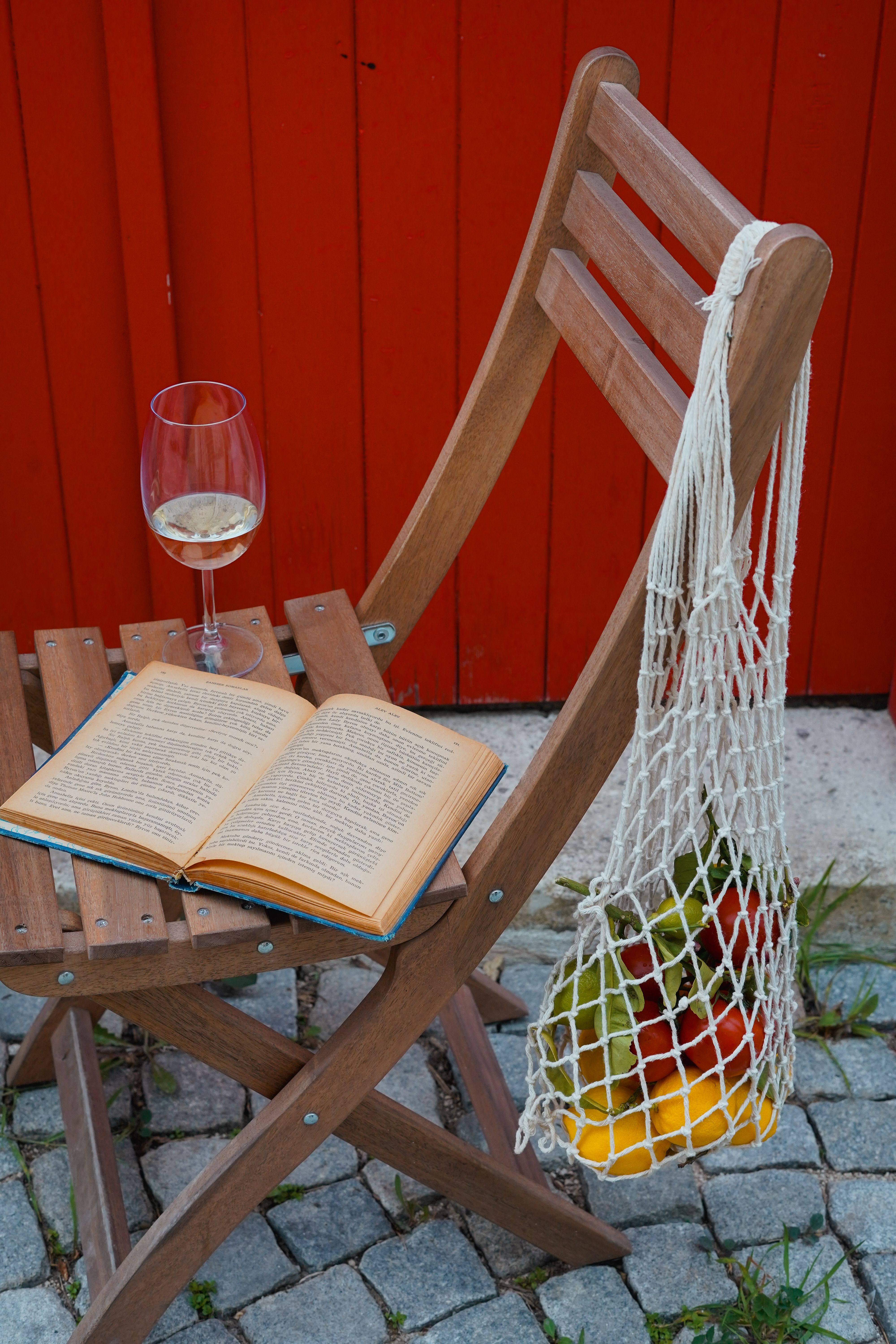 Cozy Patio Scene with Book, Wine, and Fruit · Free Stock Photo
