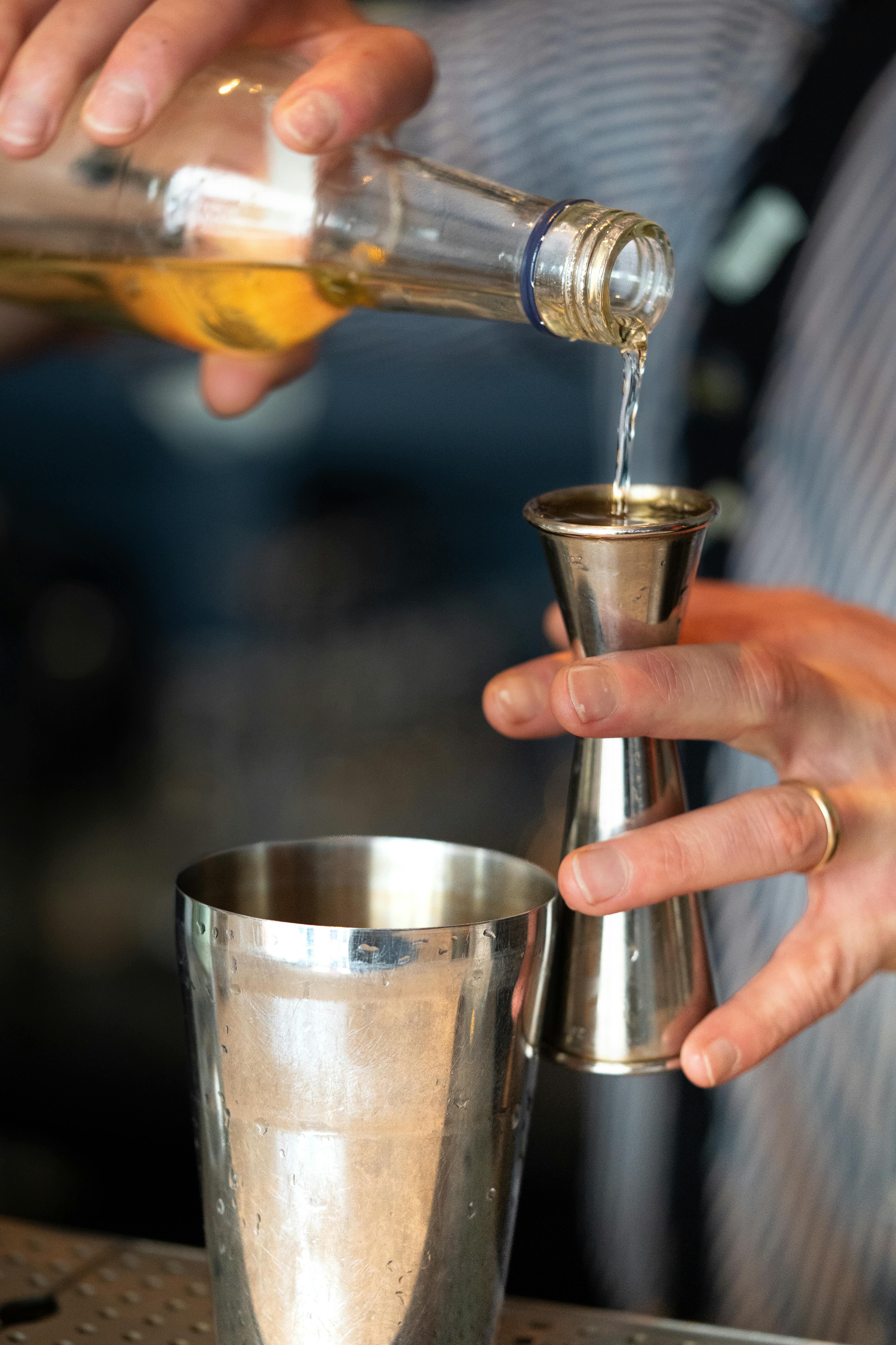 Mixologist Pouring Liquor into Jigger for Cocktail · Free Stock Photo